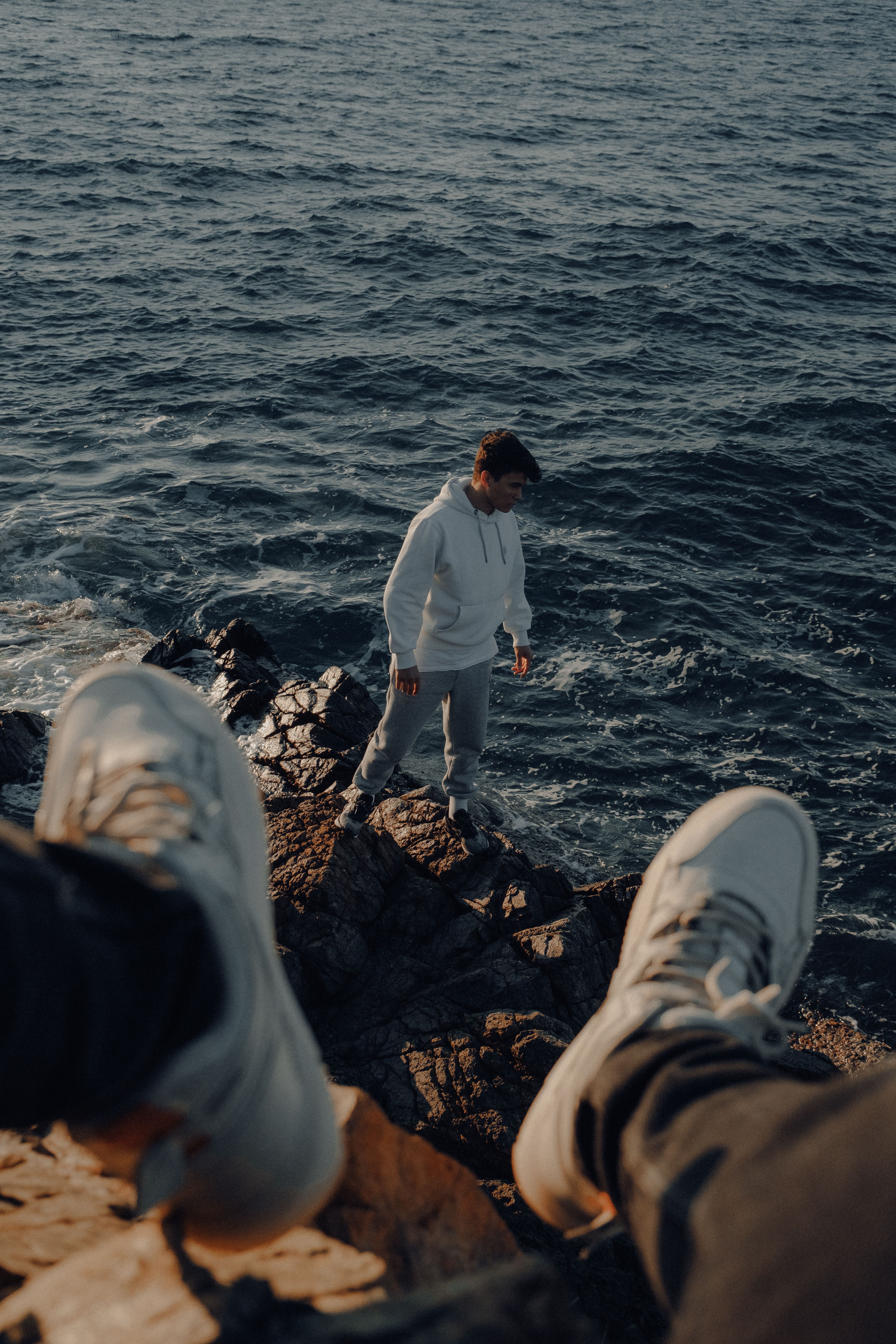 Man Standing on Rocks by Sea · Free Stock Photo