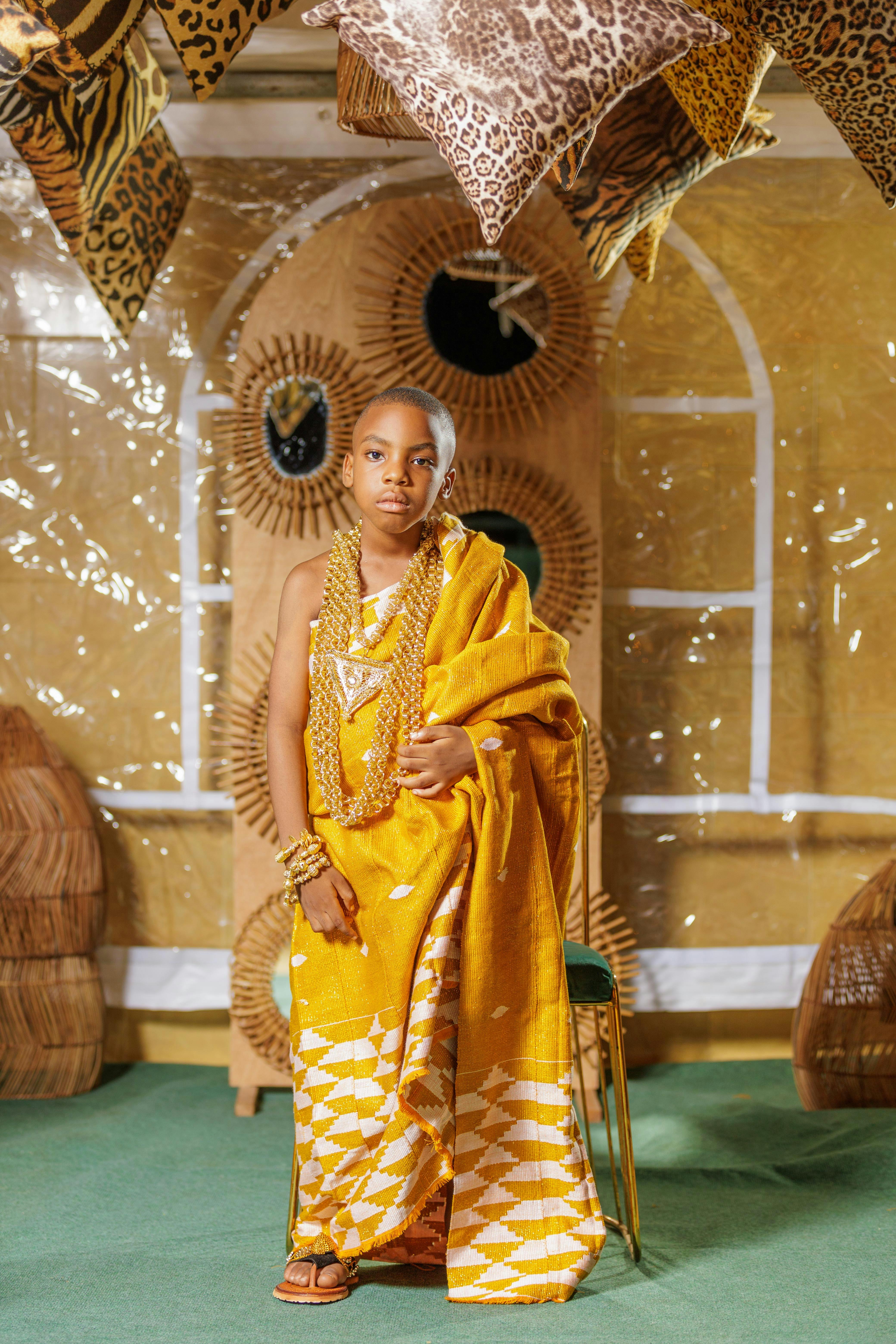 Young Boy in Traditional Blue Attire Outdoors · Free Stock Photo