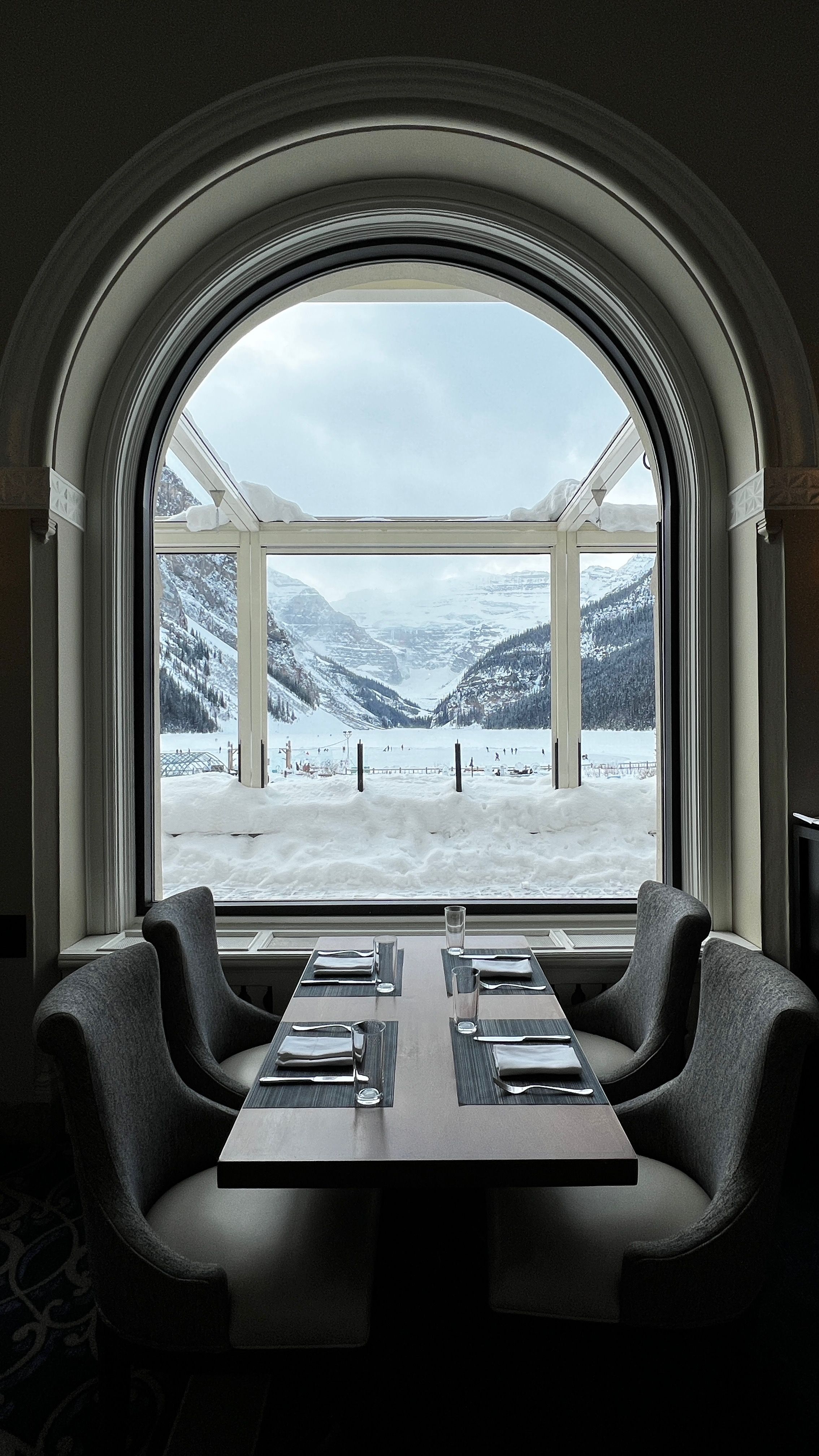 Tables and Chairs by Window with Snow behind · Free Stock Photo