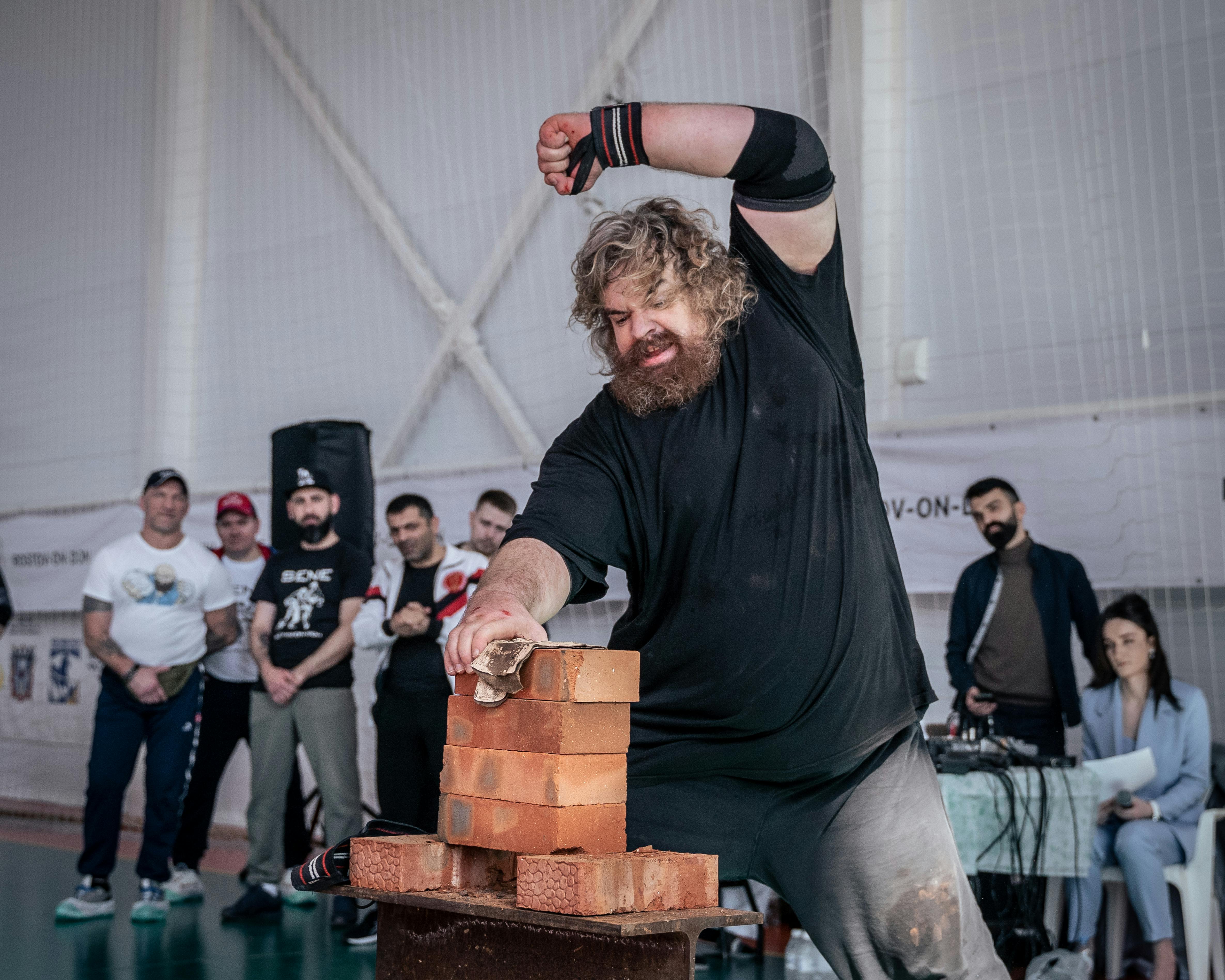 Black and White Photo of a Muscular Man Cracking Bricks and Crowd ...