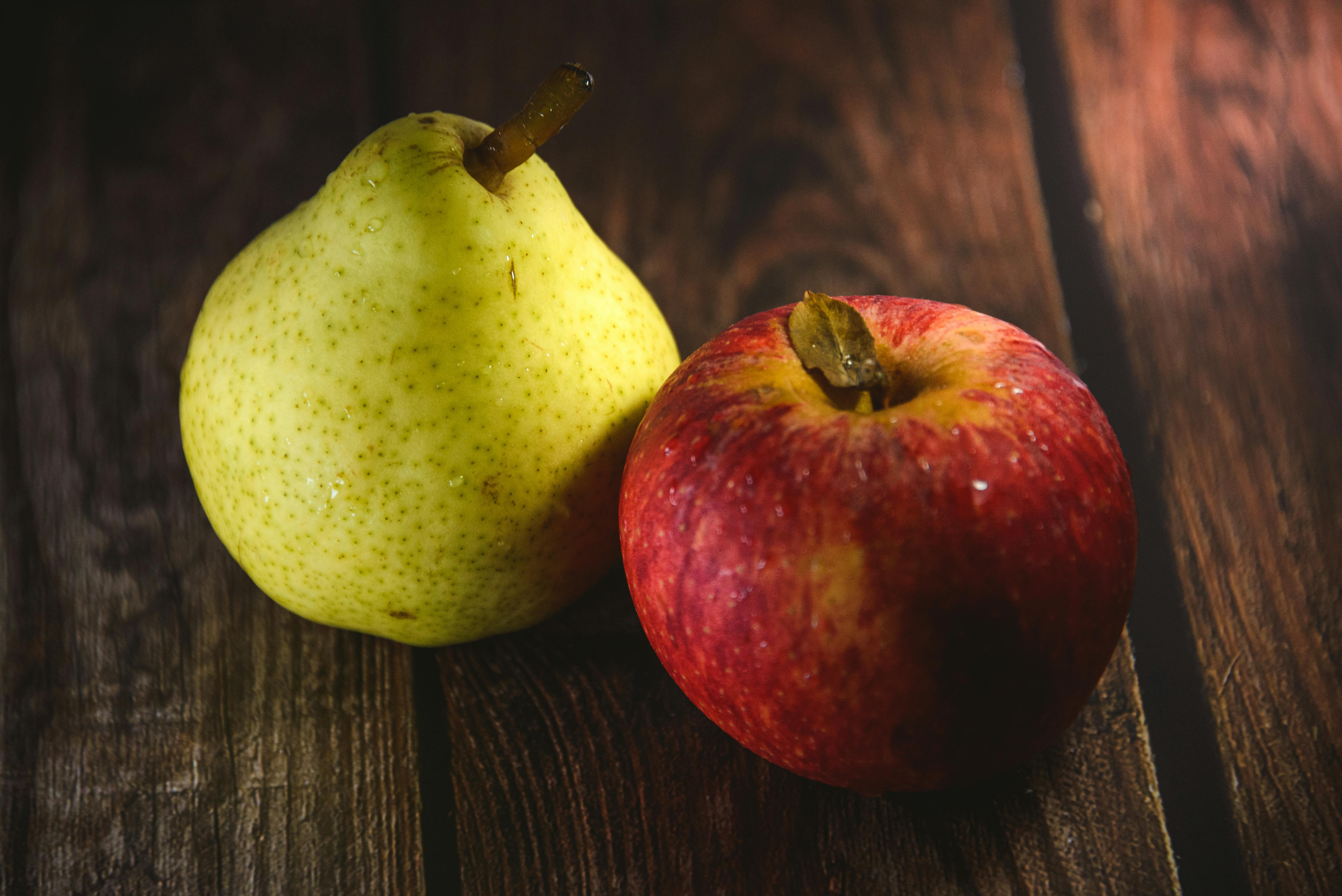 Close-up of a Red Apple and Green Pear Lying on a Wooden Surface · Free ...