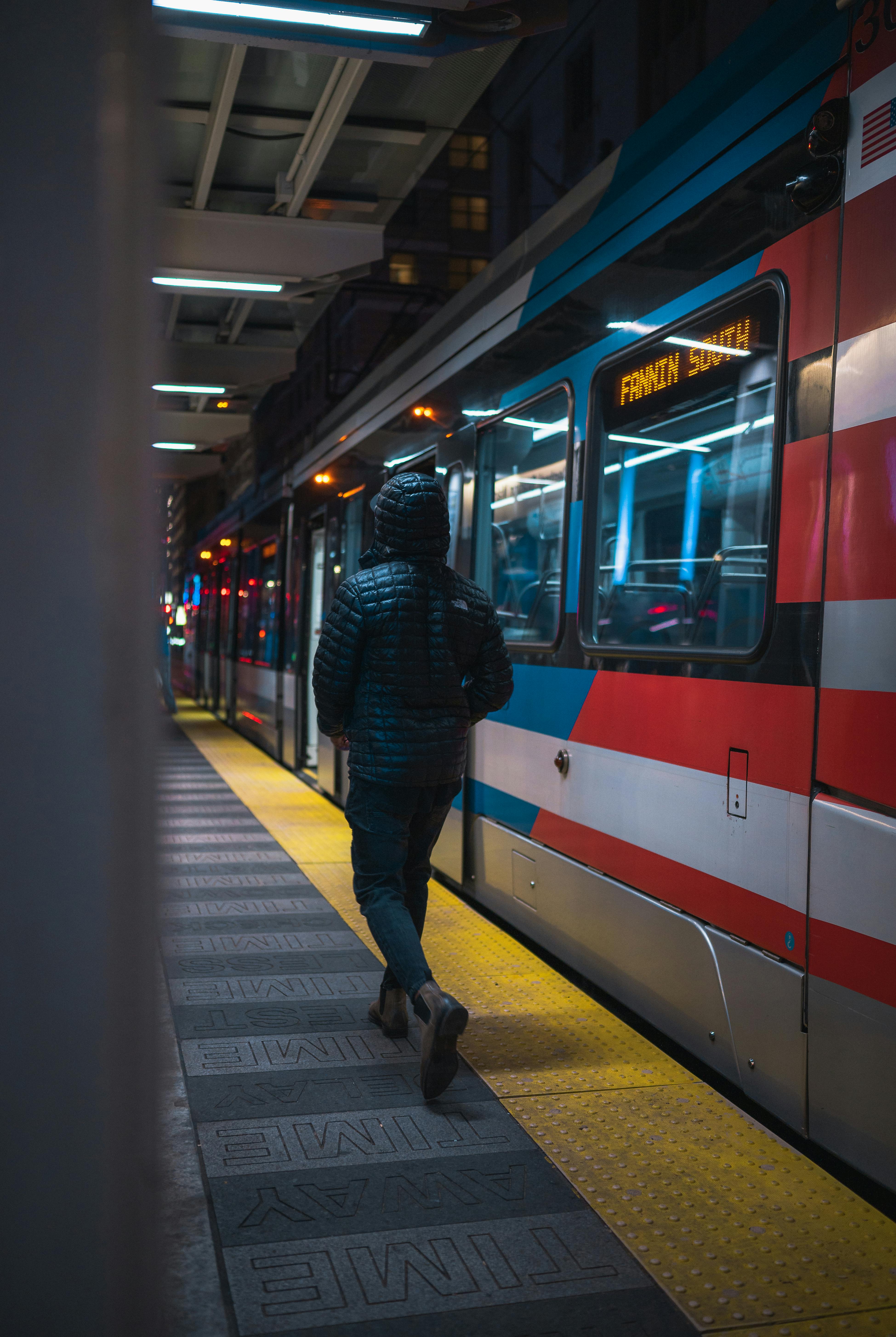 Man Walking along Running Subway Tray · Free Stock Photo