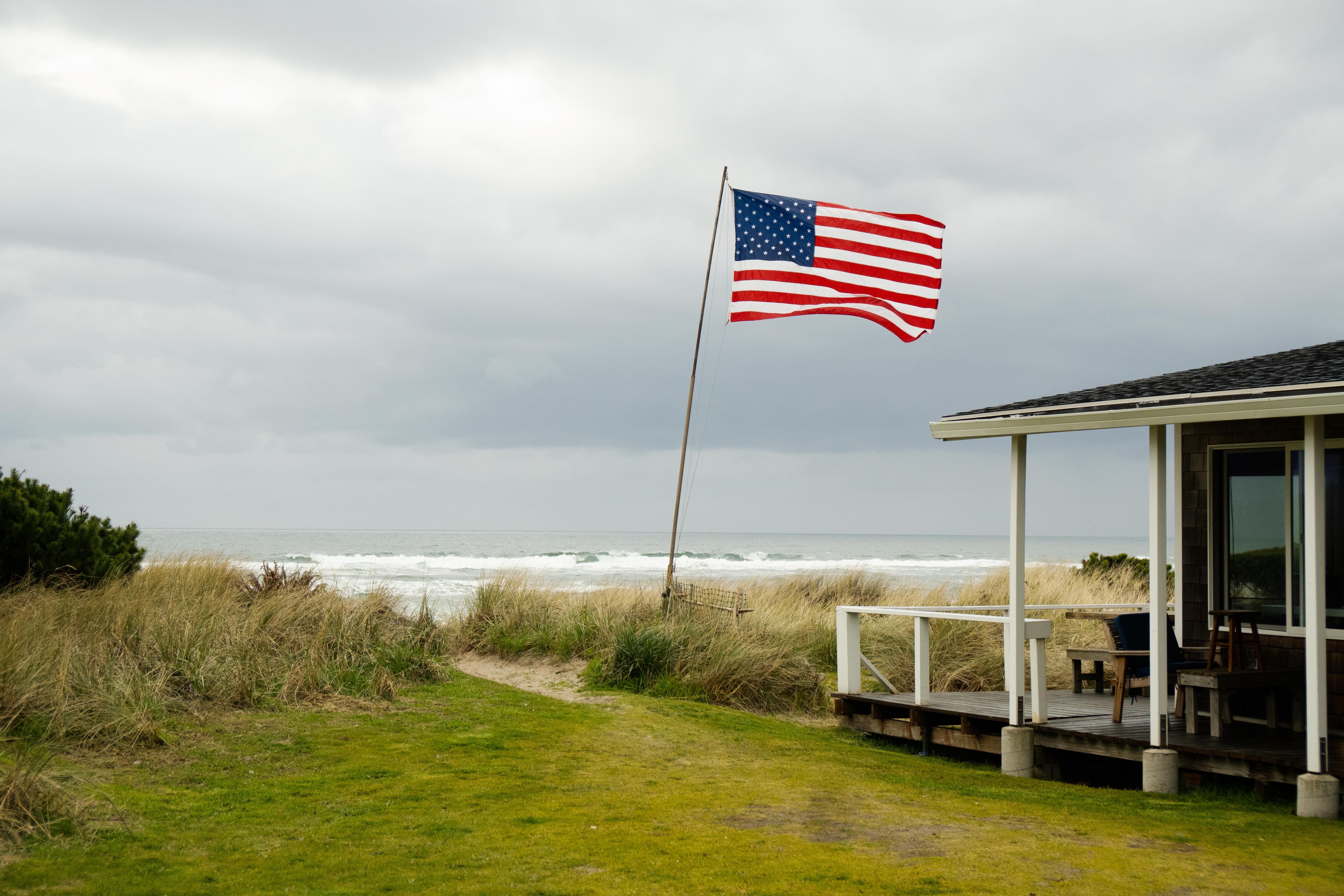 Seaside with a Hut and American Flag on a Wind · Free Stock Photo