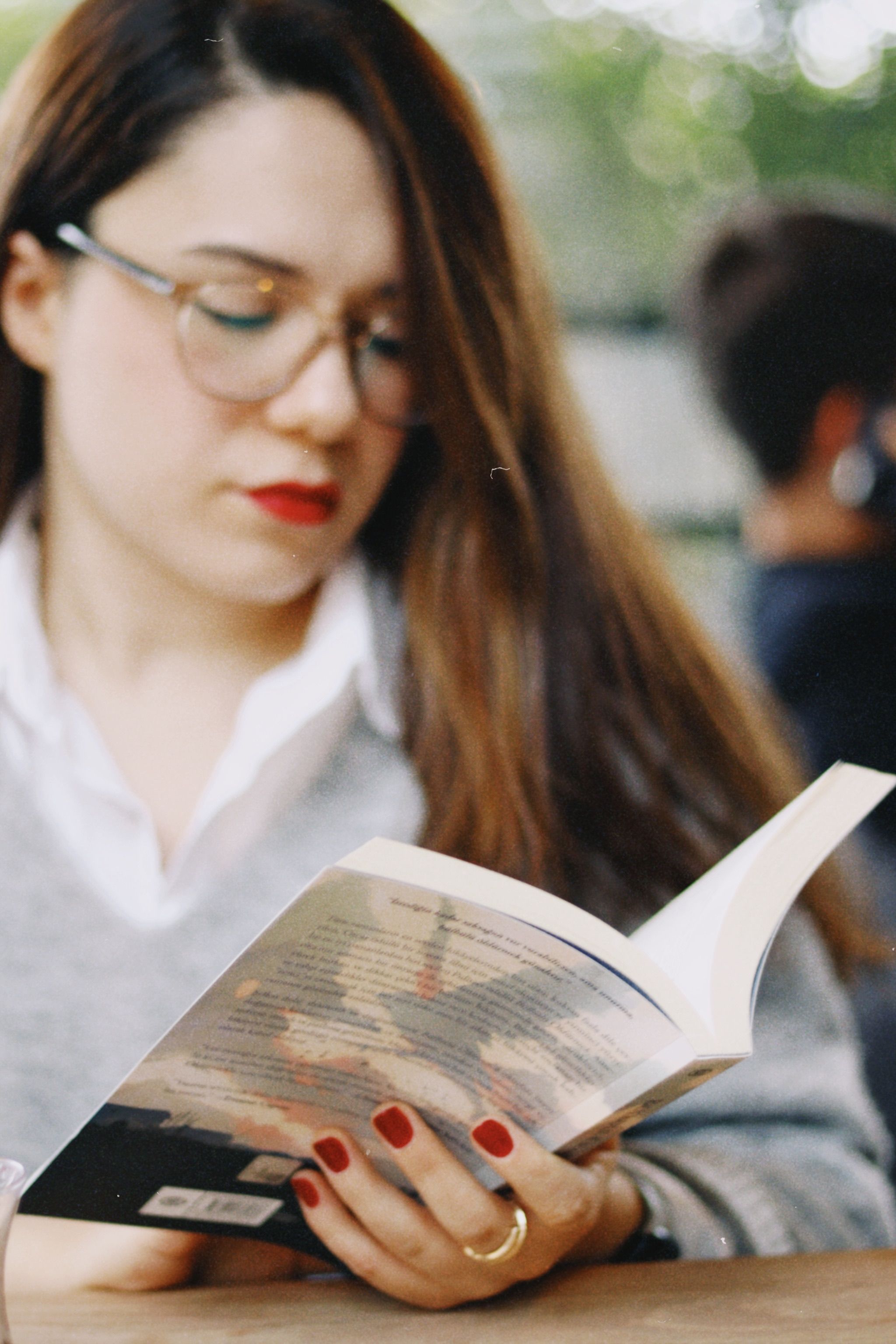Young Brunette in a Dress Sitting on a Bench and Reading a Book · Free ...