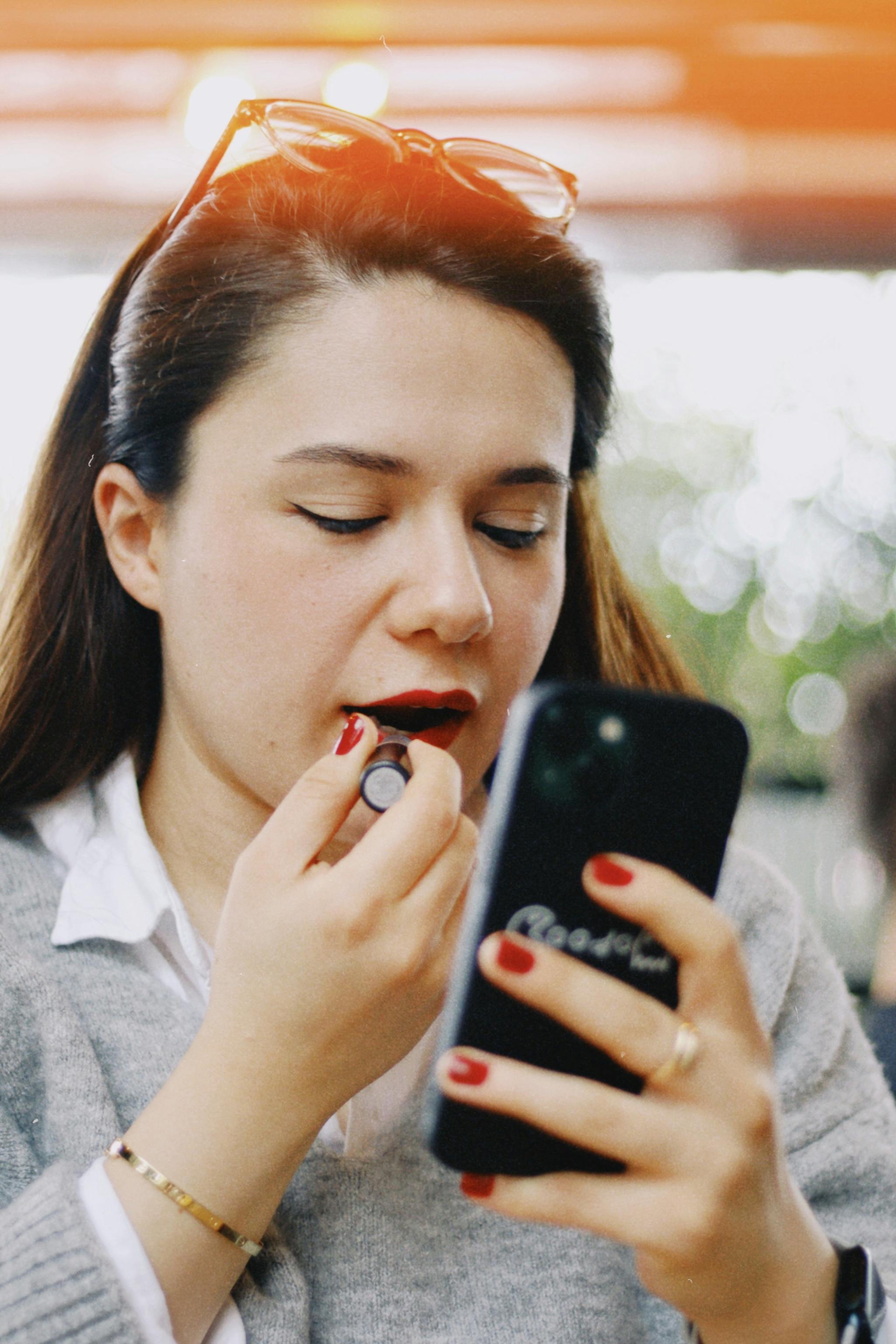 Woman Applying Makeup with Cellphone · Free Stock Photo
