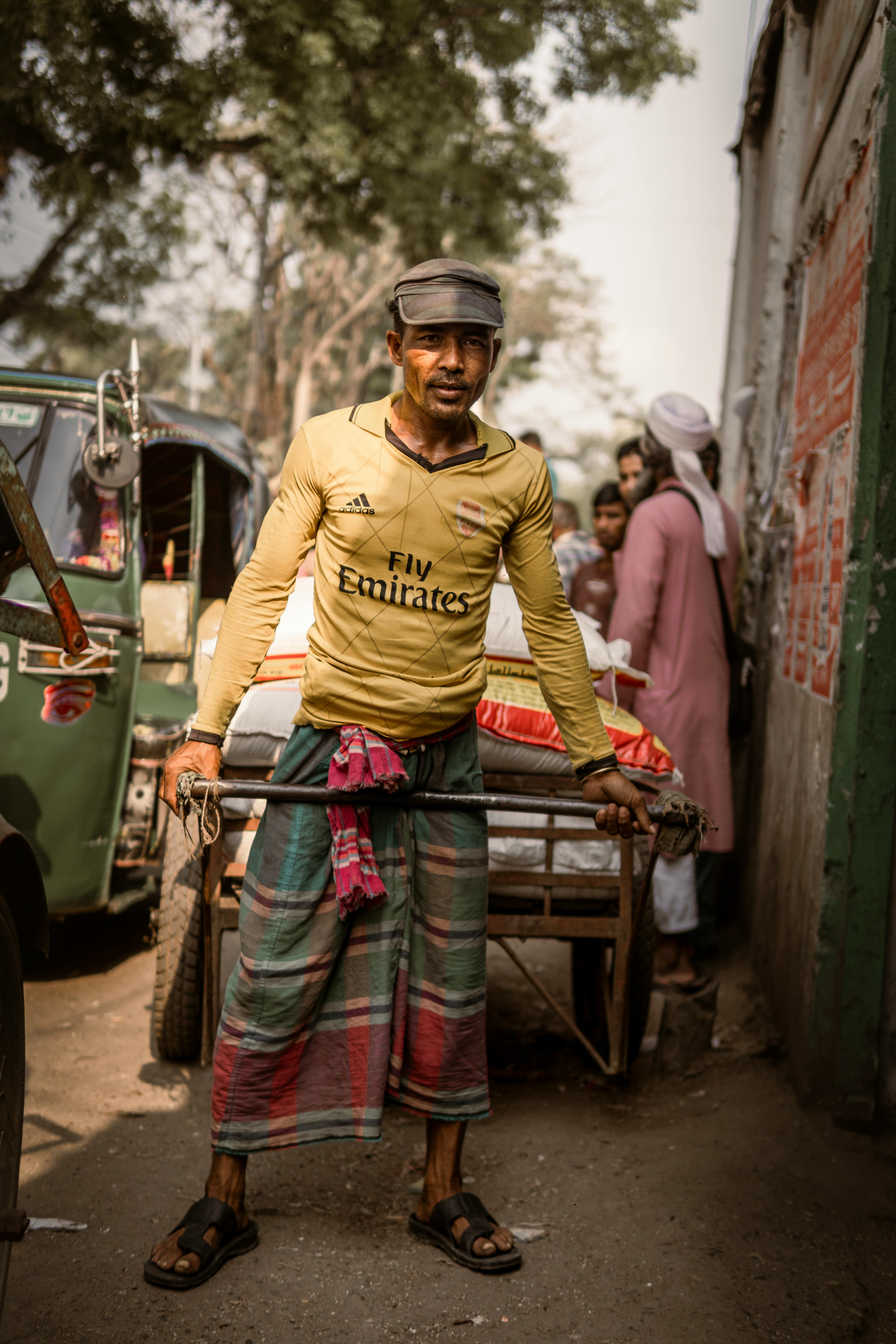 Man in Arsenal Jersey Holding Trailer in Town · Free Stock Photo
