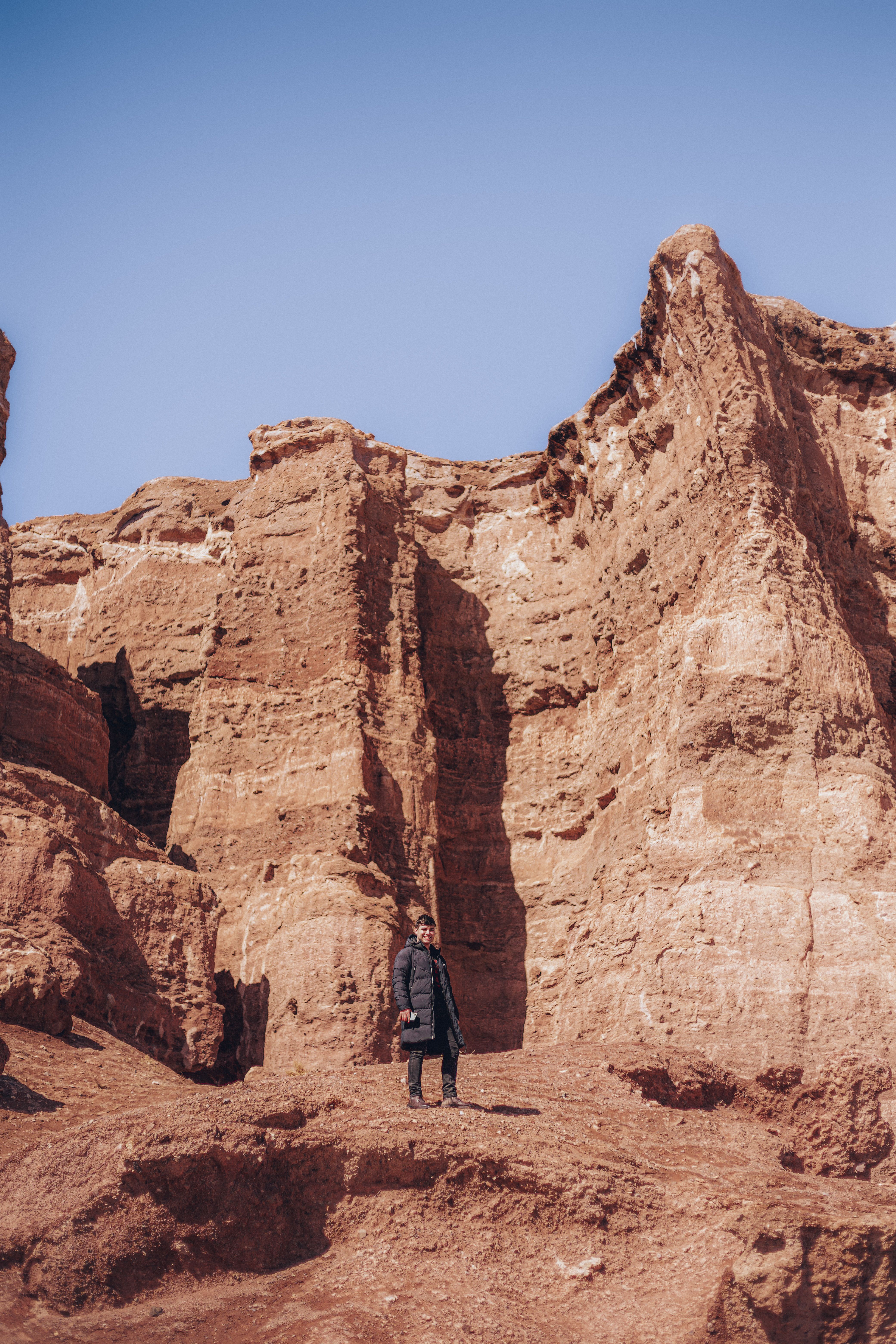 A Woman Wearing a Hard Hat Standing under Rock Formations · Free Stock ...