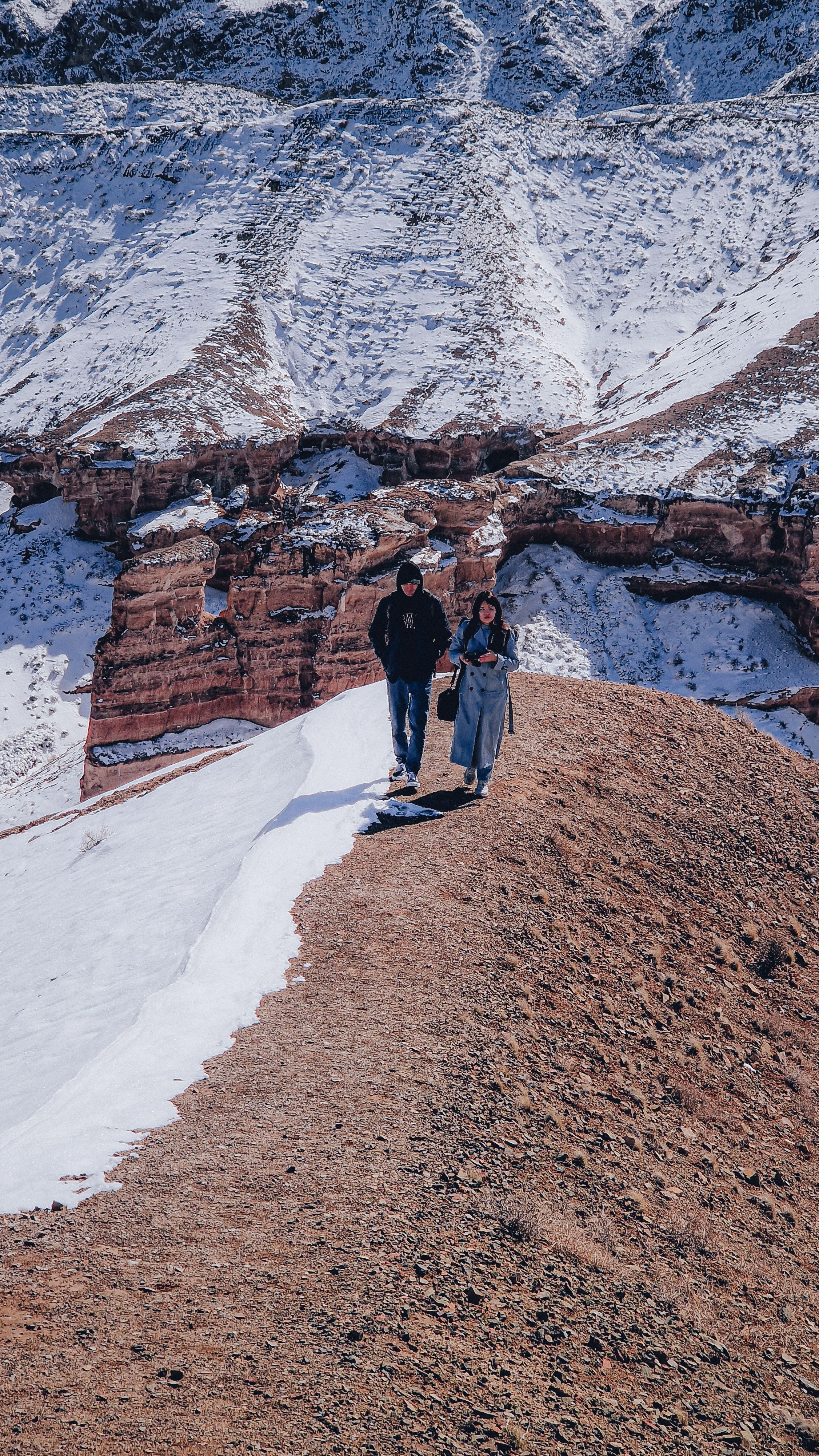 Woman and Man on Sunlit Hill in Winter · Free Stock Photo