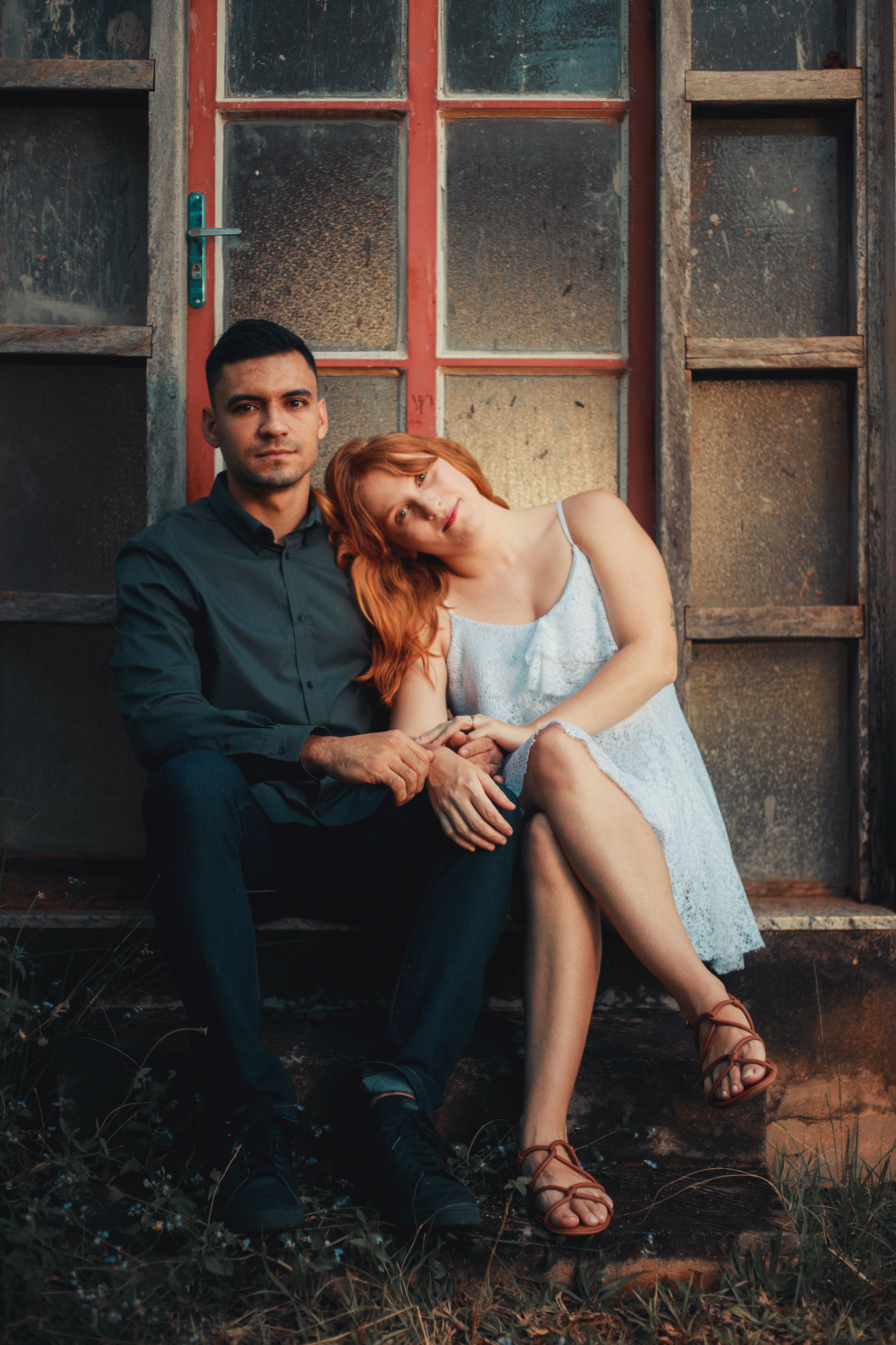 Couple Sitting and Posing by Door with Windows · Free Stock Photo