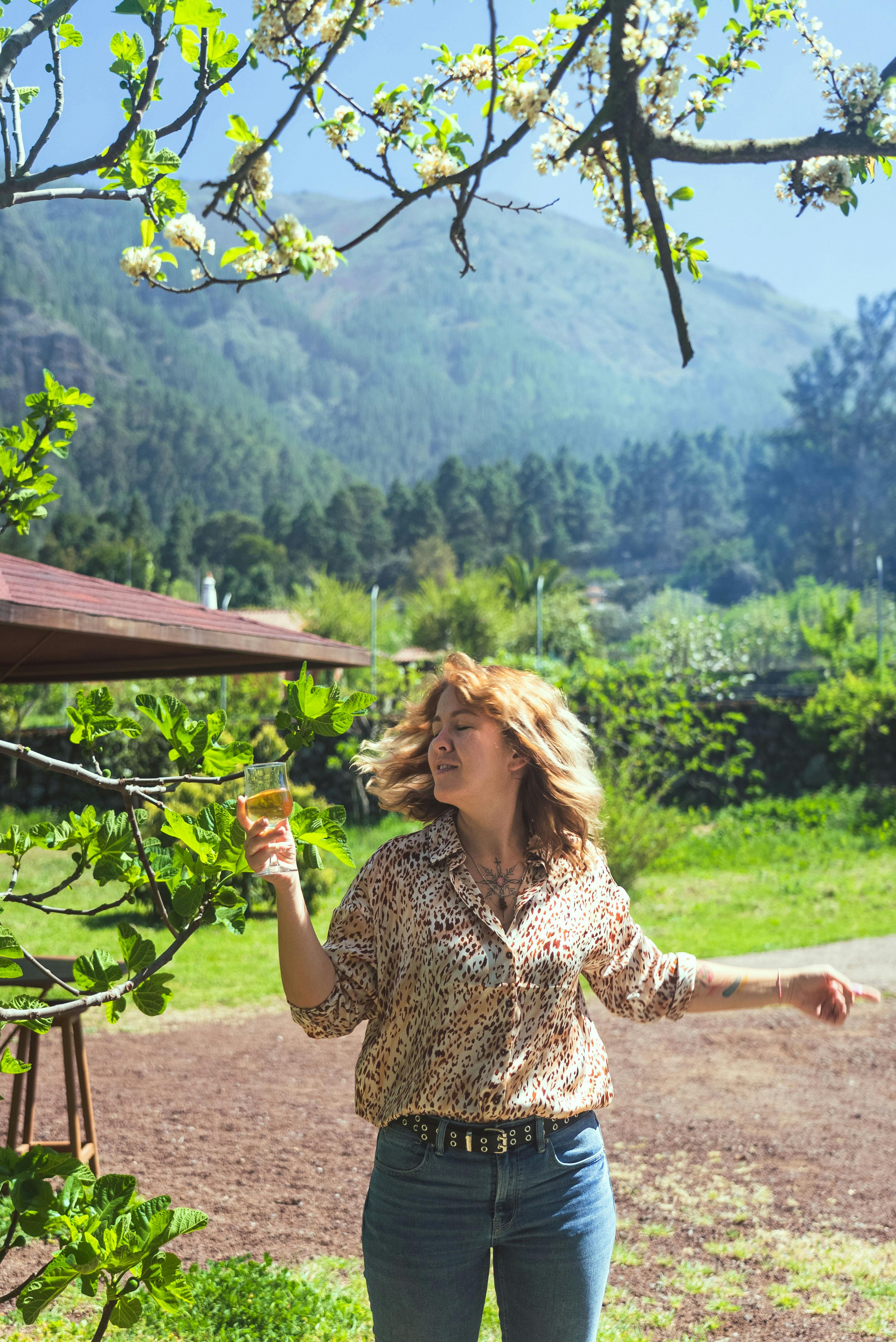 Smiling Woman with Glass of Wine Dancing in Countryside · Free Stock Photo