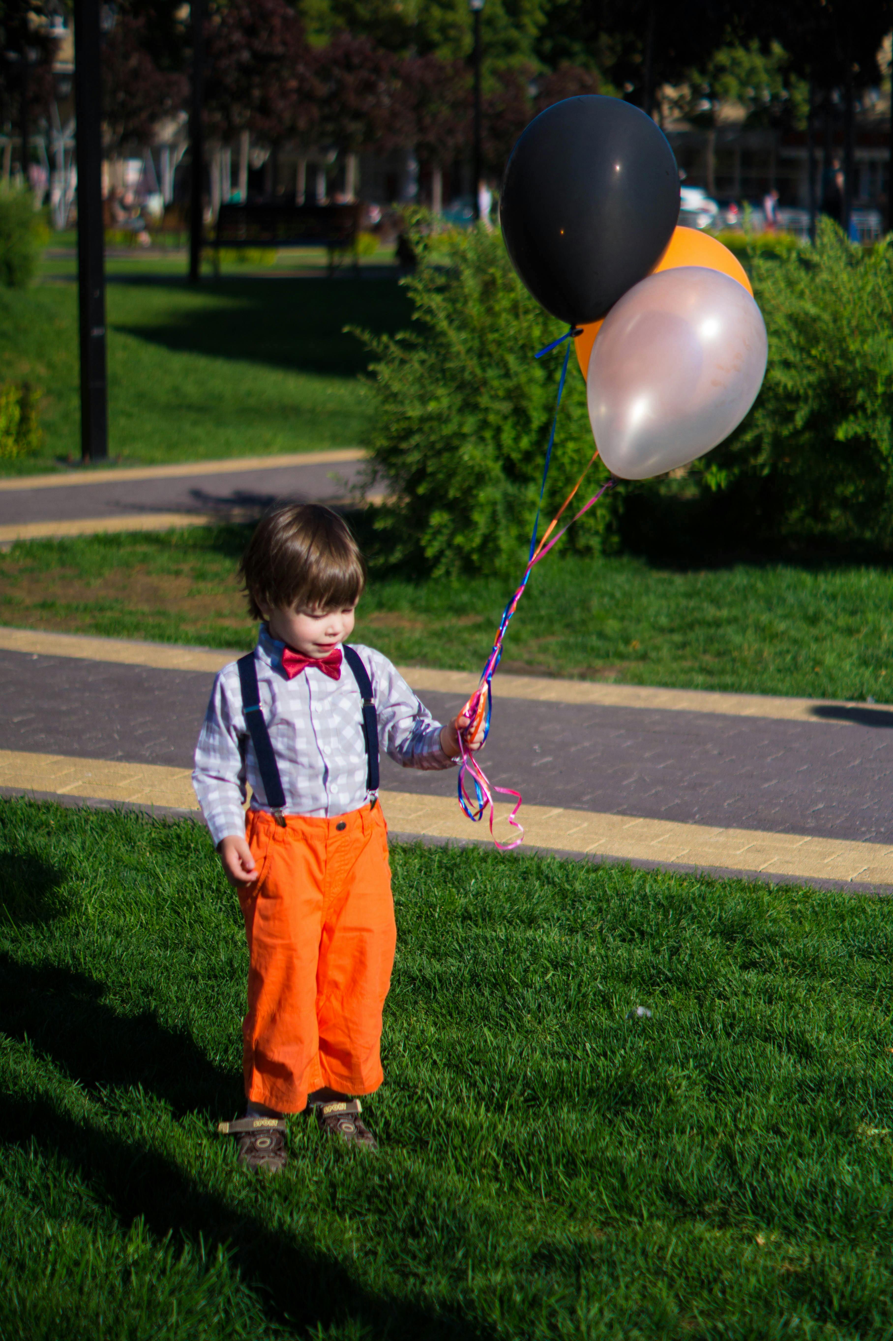 Photo of Boy Holding Balloons · Free Stock Photo