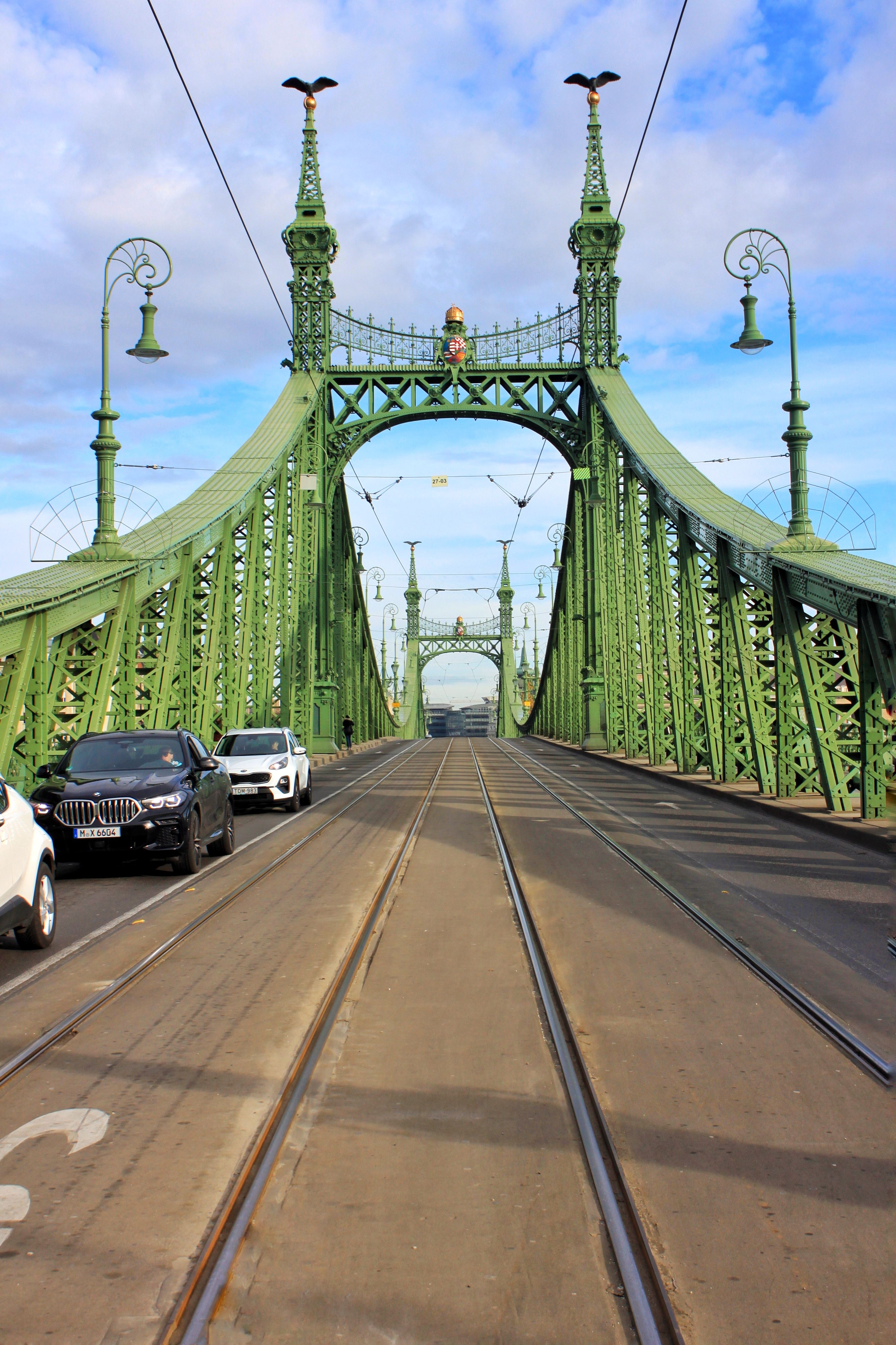 A green bridge with cars driving on it · Free Stock Photo