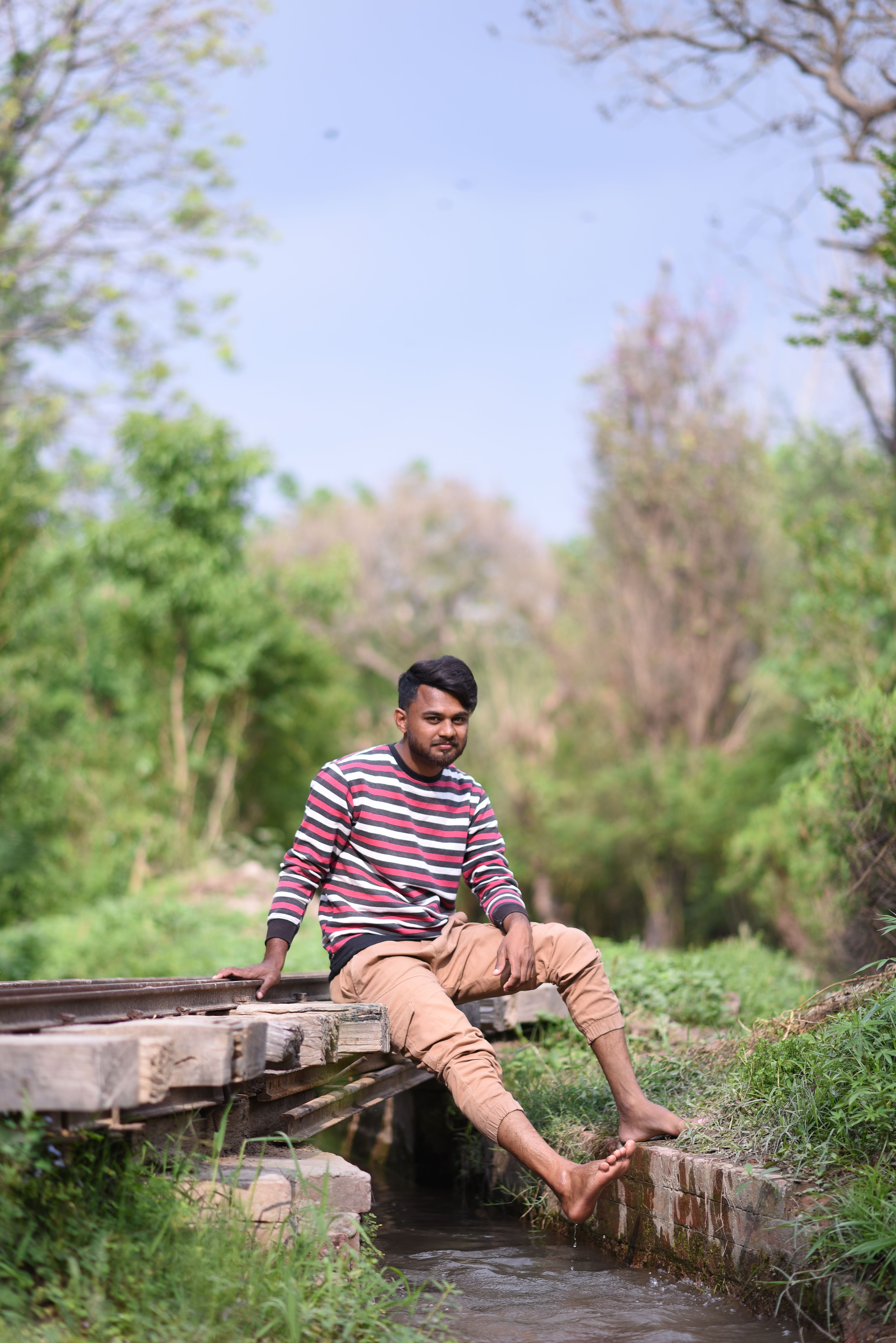 Young Man Sitting over a Small Stream · Free Stock Photo