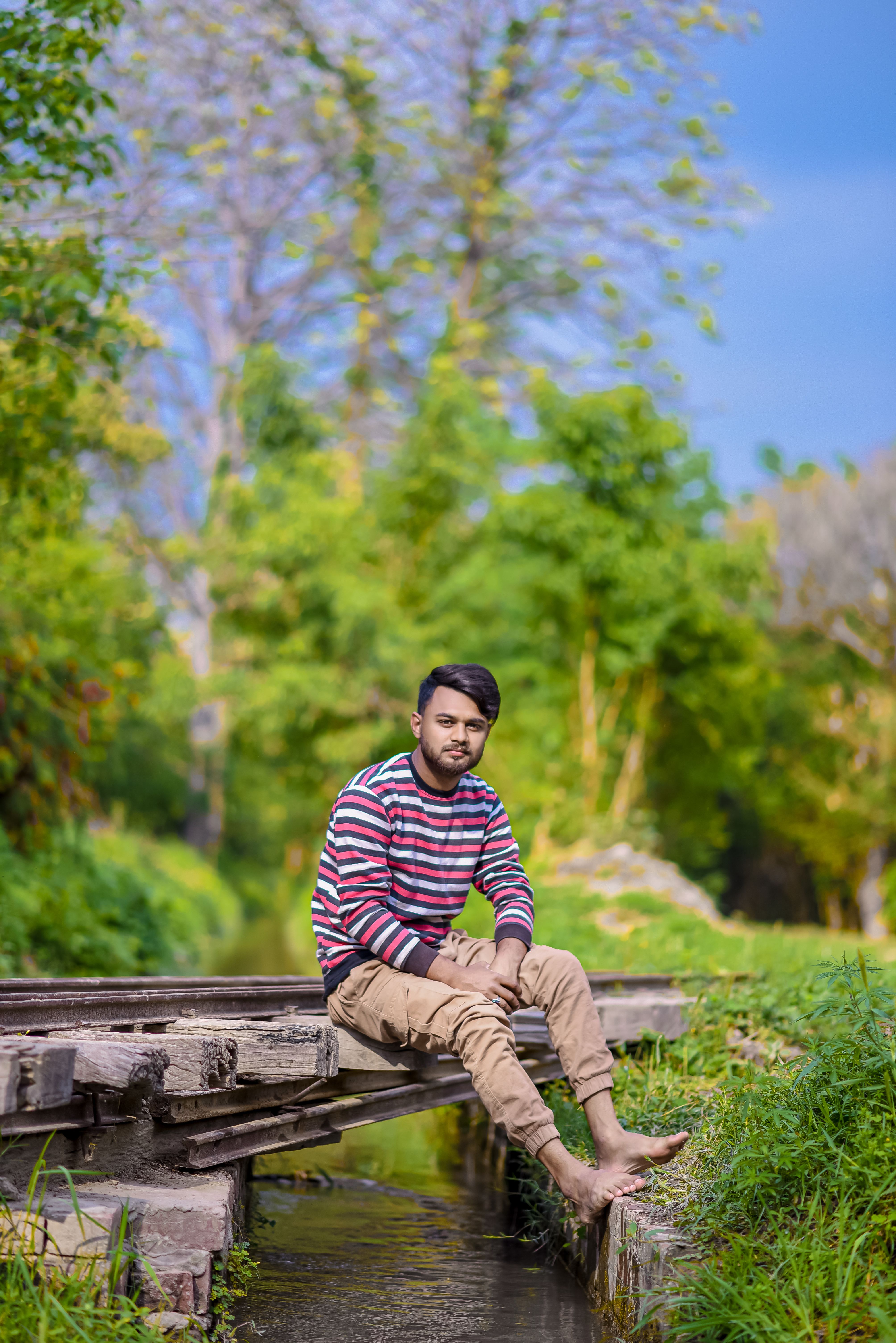 Portrait of a Young Man Sitting over a Small Stream · Free Stock Photo