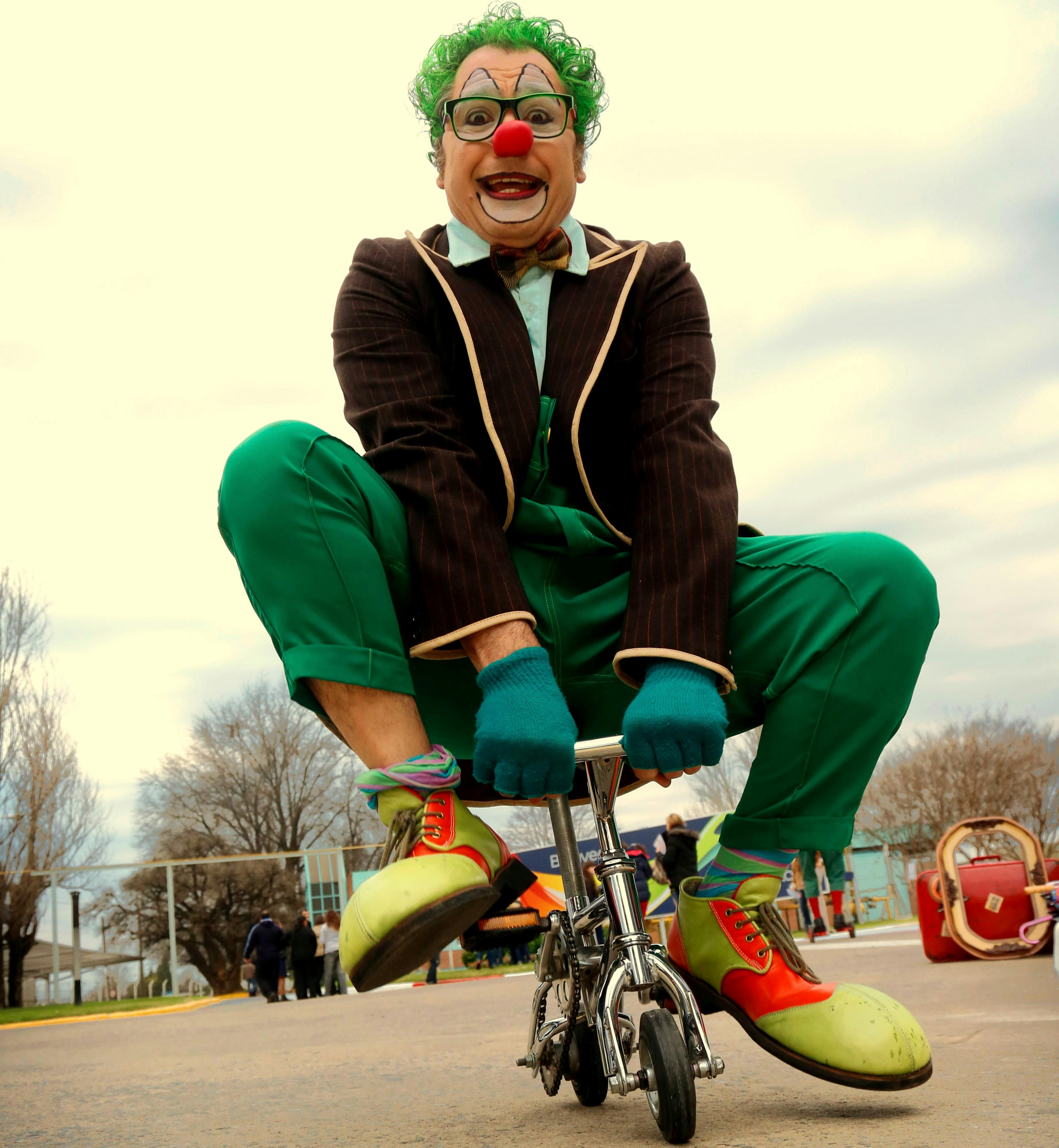 Man Dressed as a Clown Riding on a Tiny Bicycle · Free Stock Photo