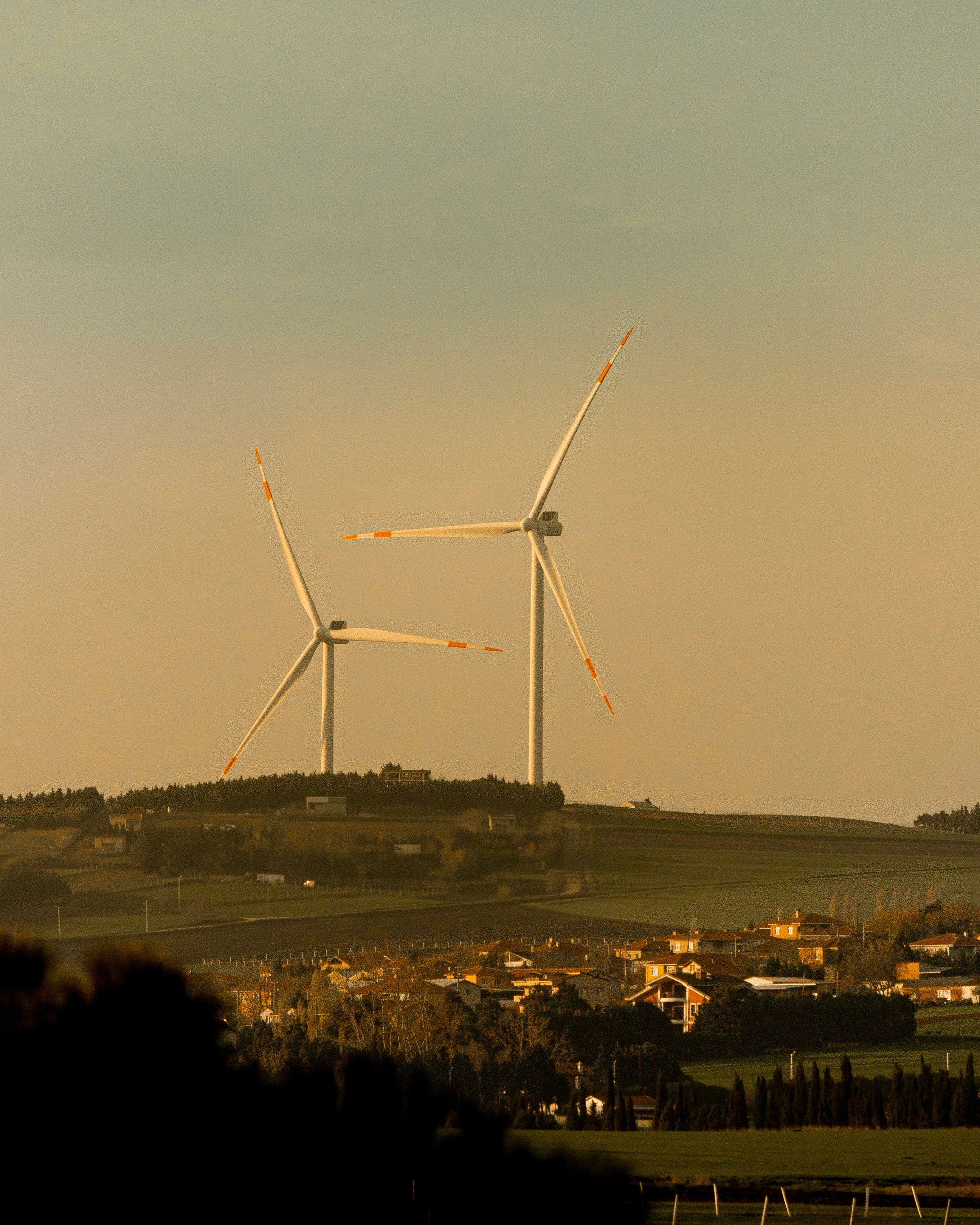 Two wind turbines are seen in the distance · Free Stock Photo