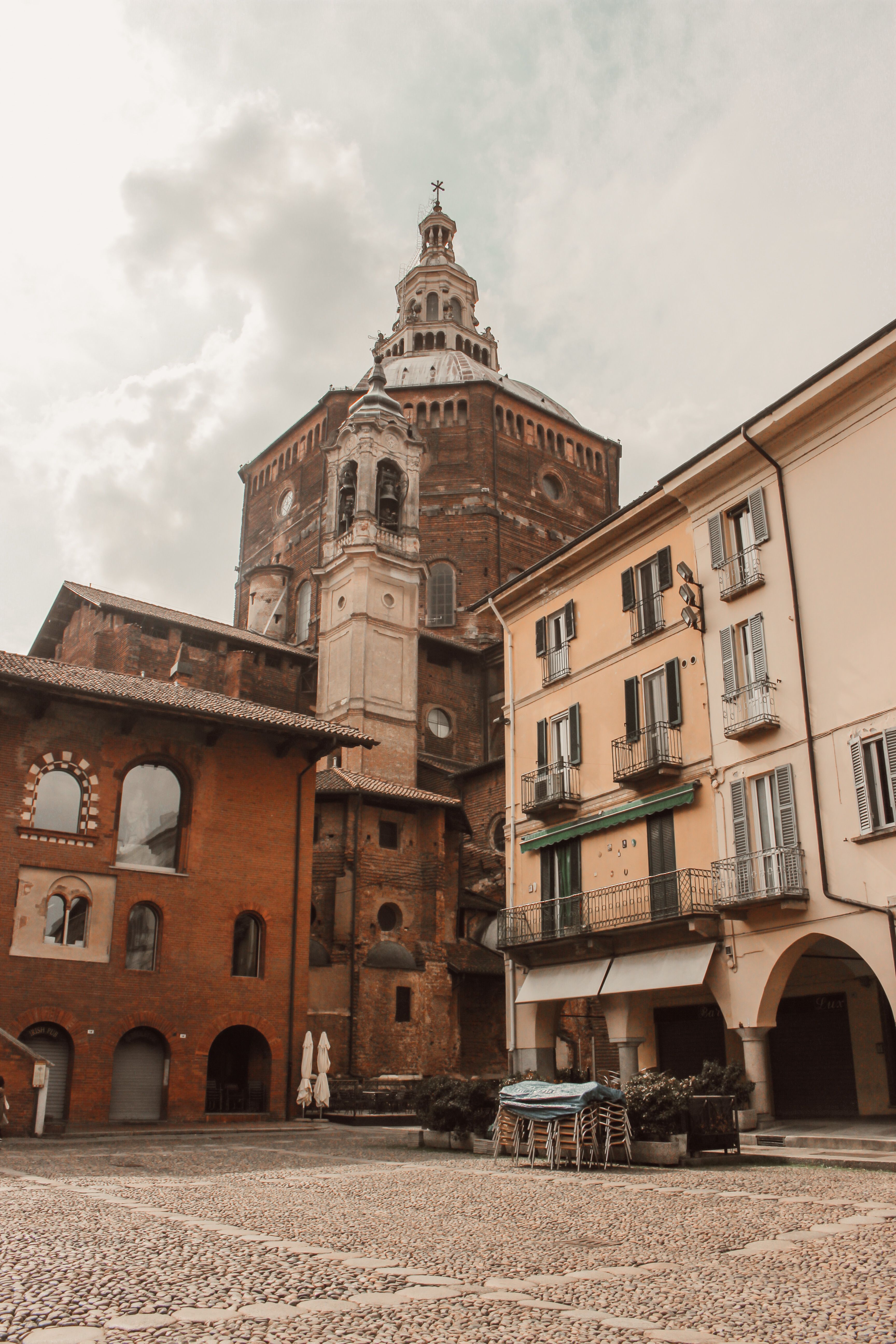 Church Tower behind Buildings on Square in Old Town · Free Stock Photo