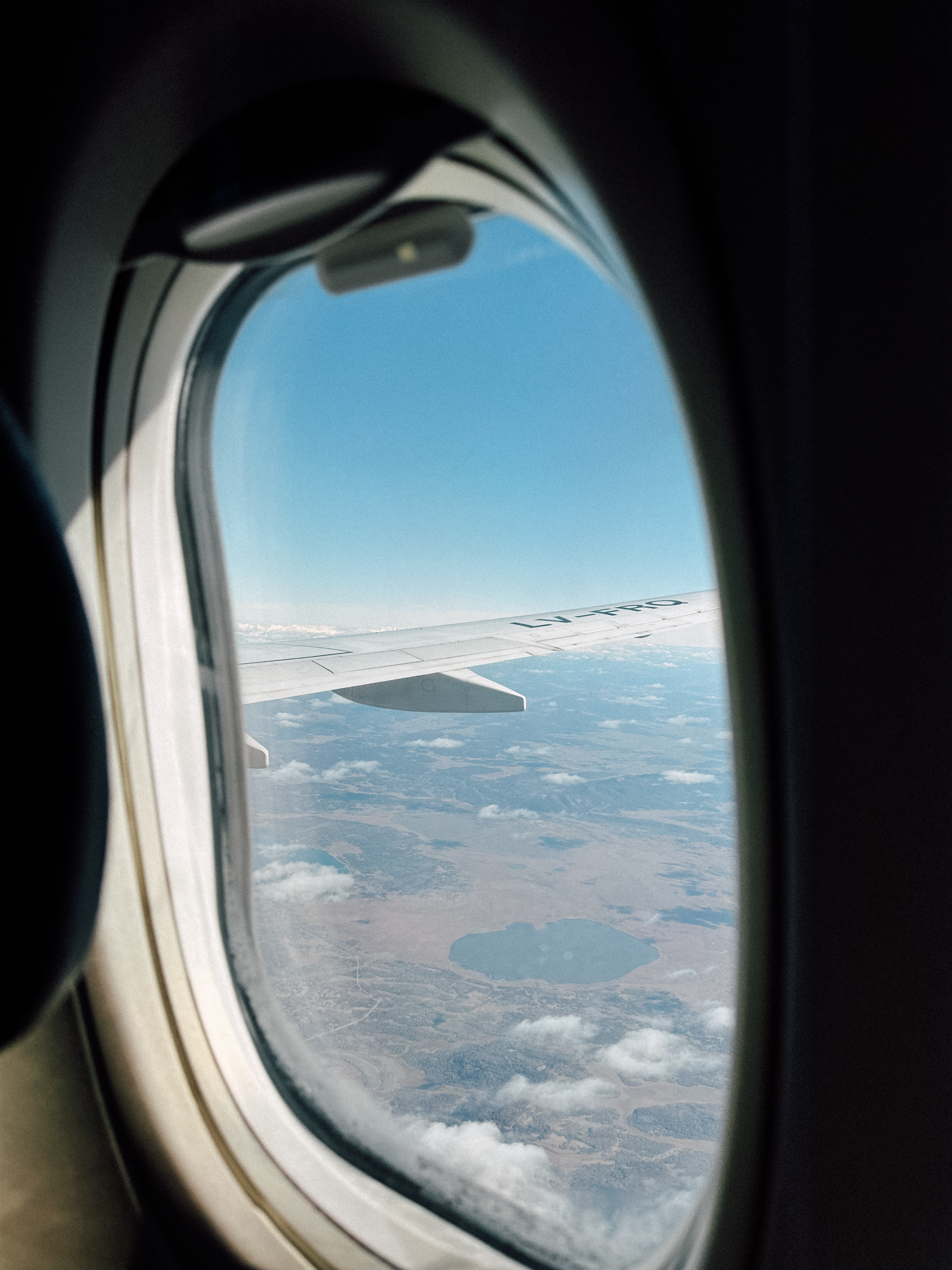Wing of Flying Airplane behind Window · Free Stock Photo