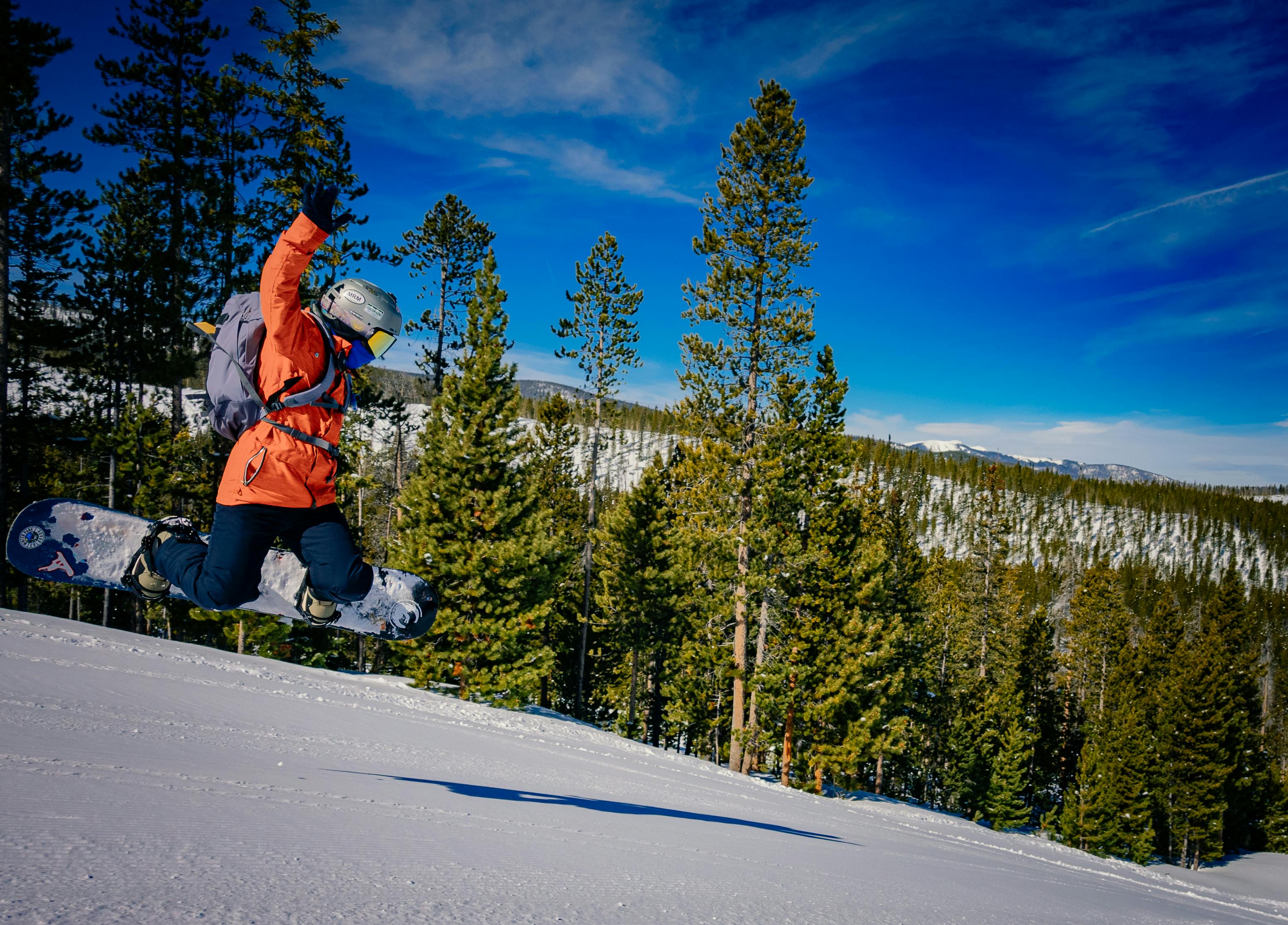 Photography of Men in Orange Suits Ridding Snowboard · Free Stock Photo