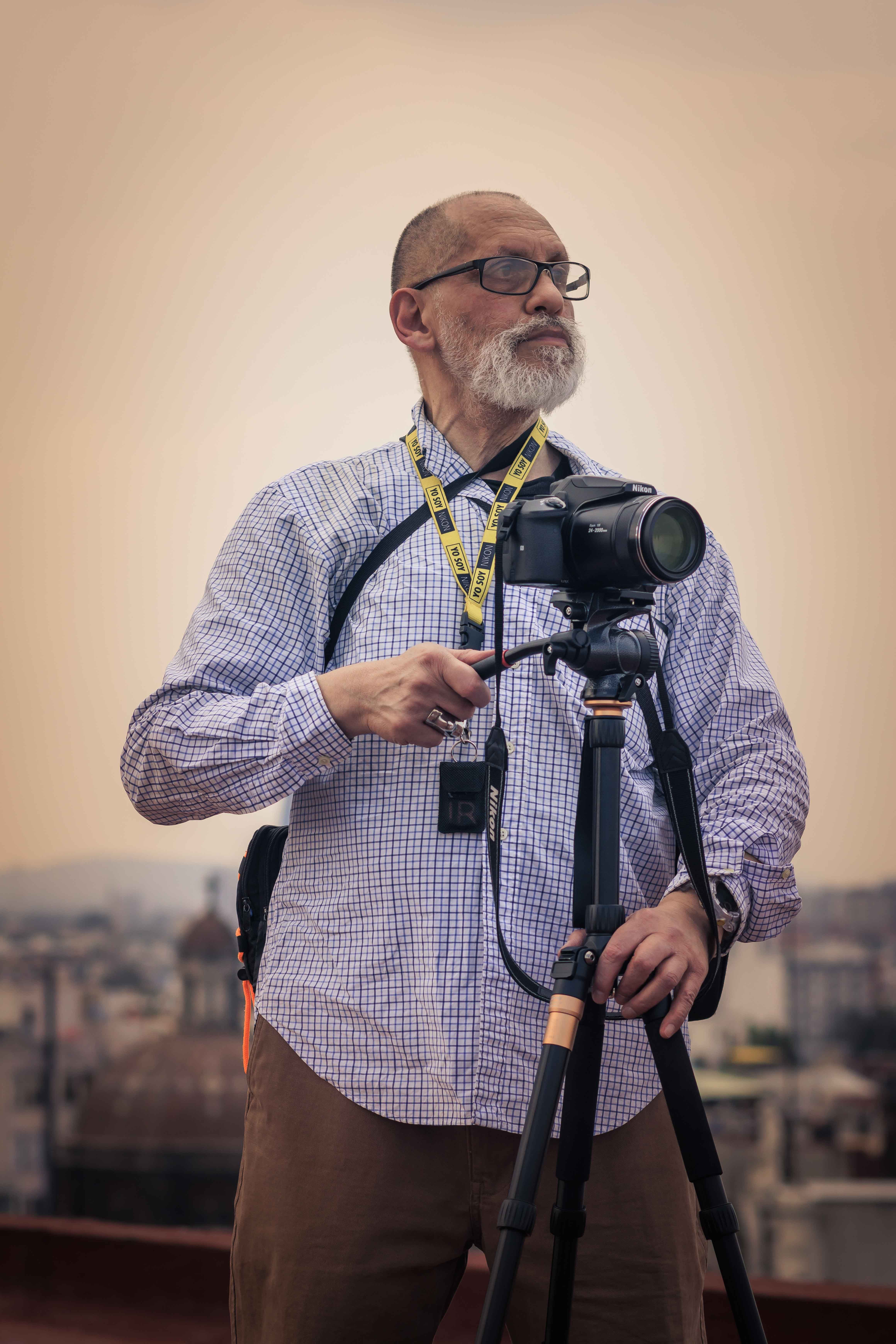 Portrait of a Photographer with a Camera on a Tripod · Free Stock Photo