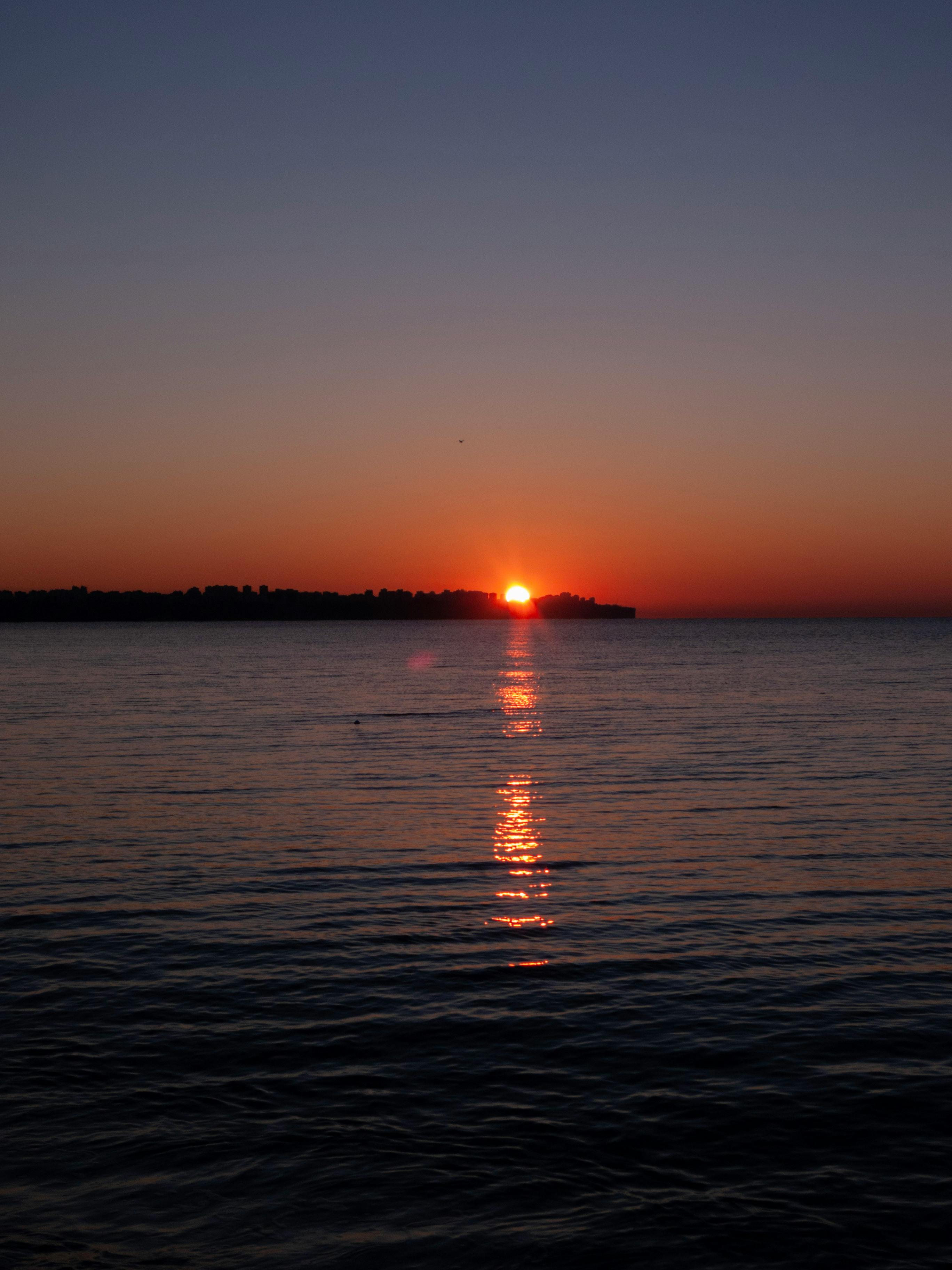 Sunset over Open Water under Clear Sky · Free Stock Photo