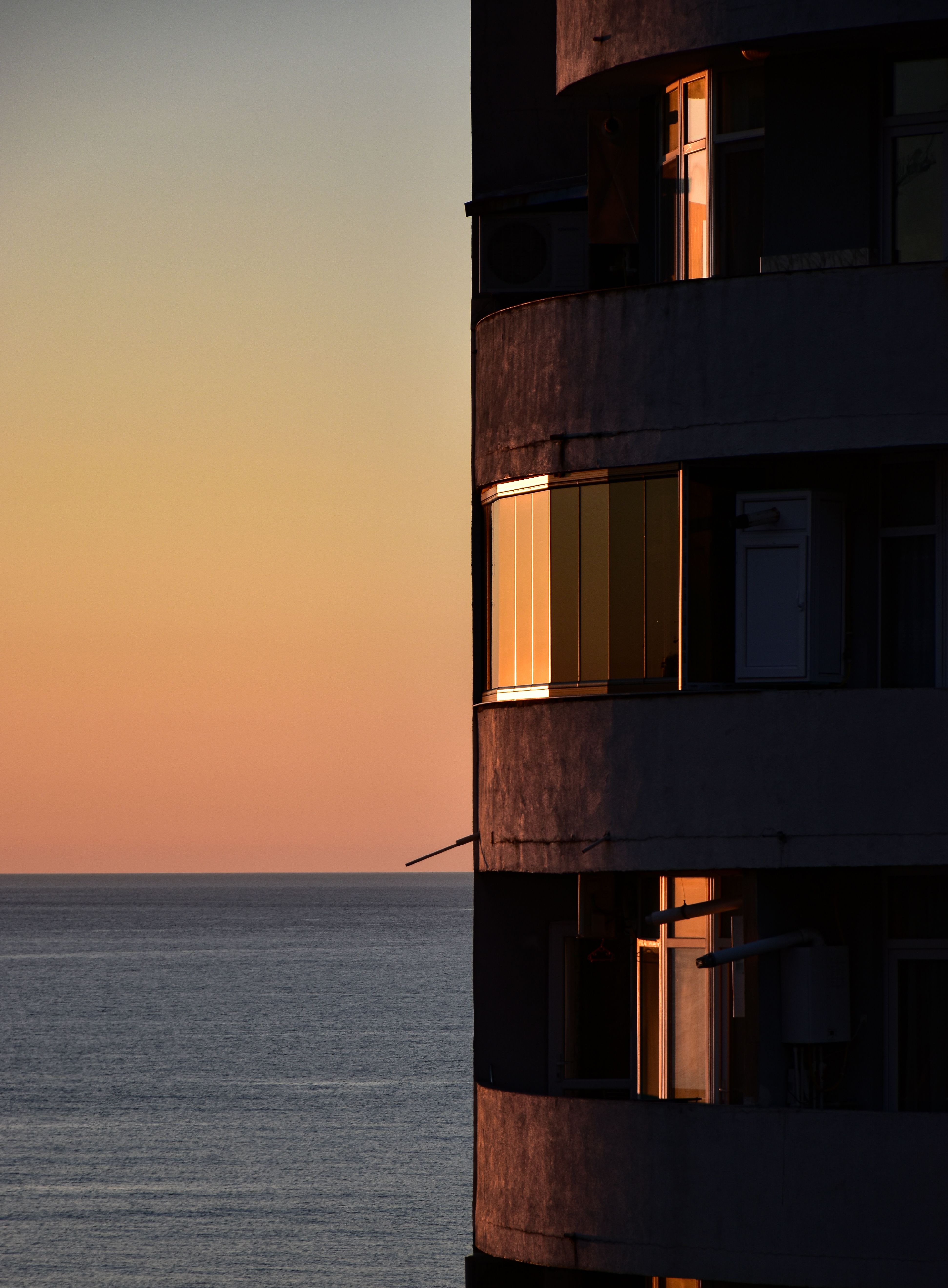 Sunset Reflecting in a Residential Building by the Sea · Free Stock Photo