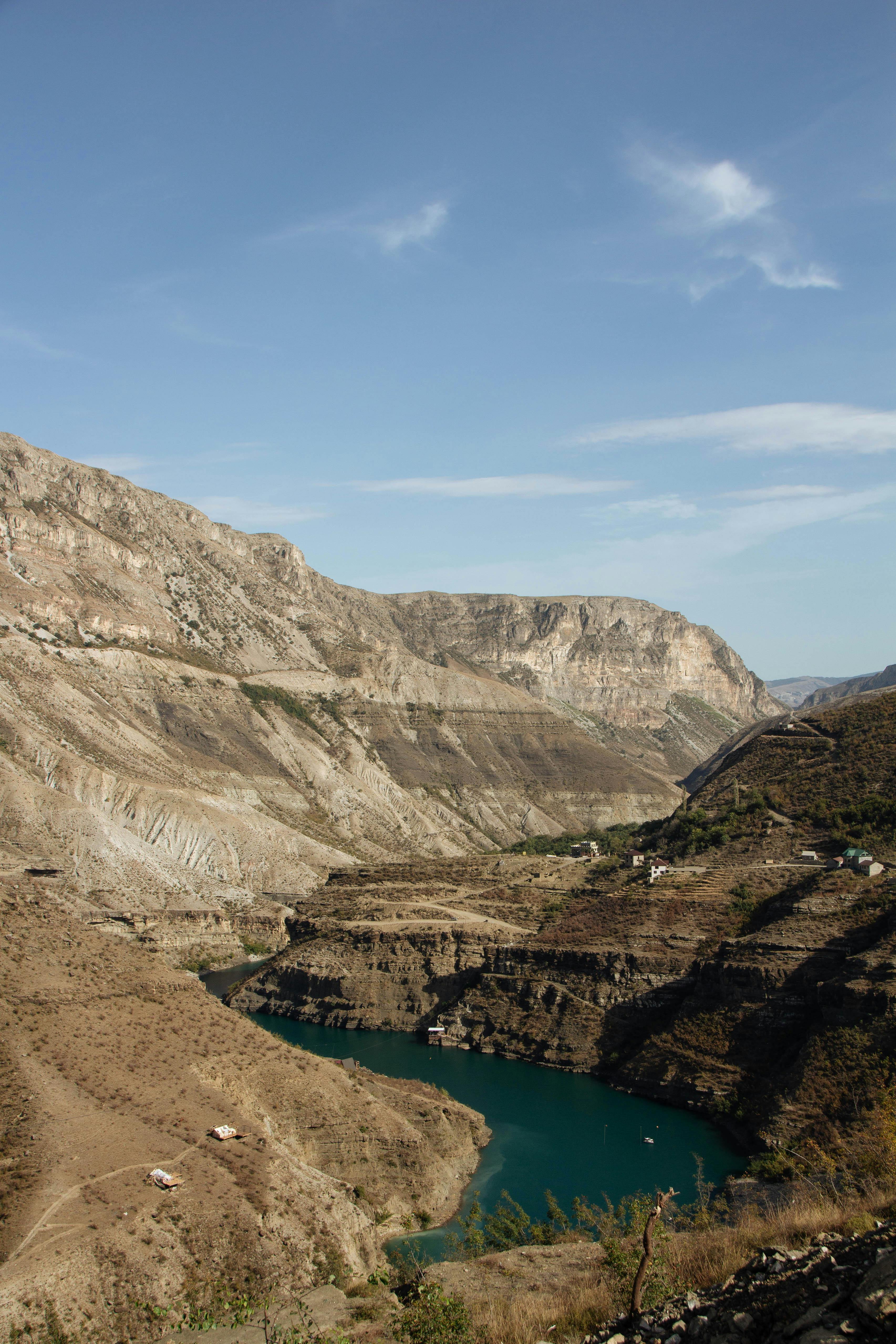 Close Up Photo of Black Rock Formation With Litter Amount of River in ...