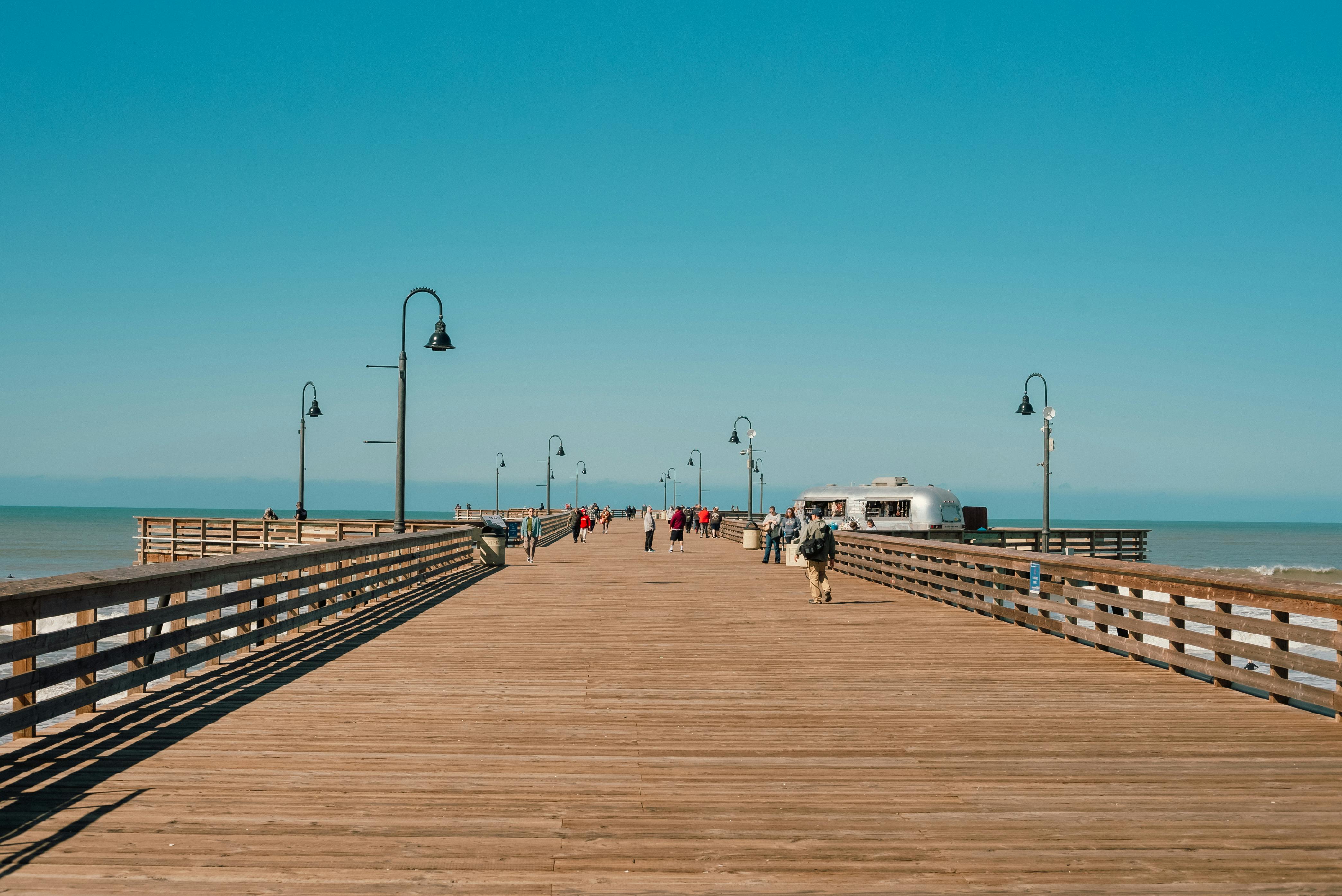 People Walking on Bridge with Wooden Posts on a Body of Water · Free ...