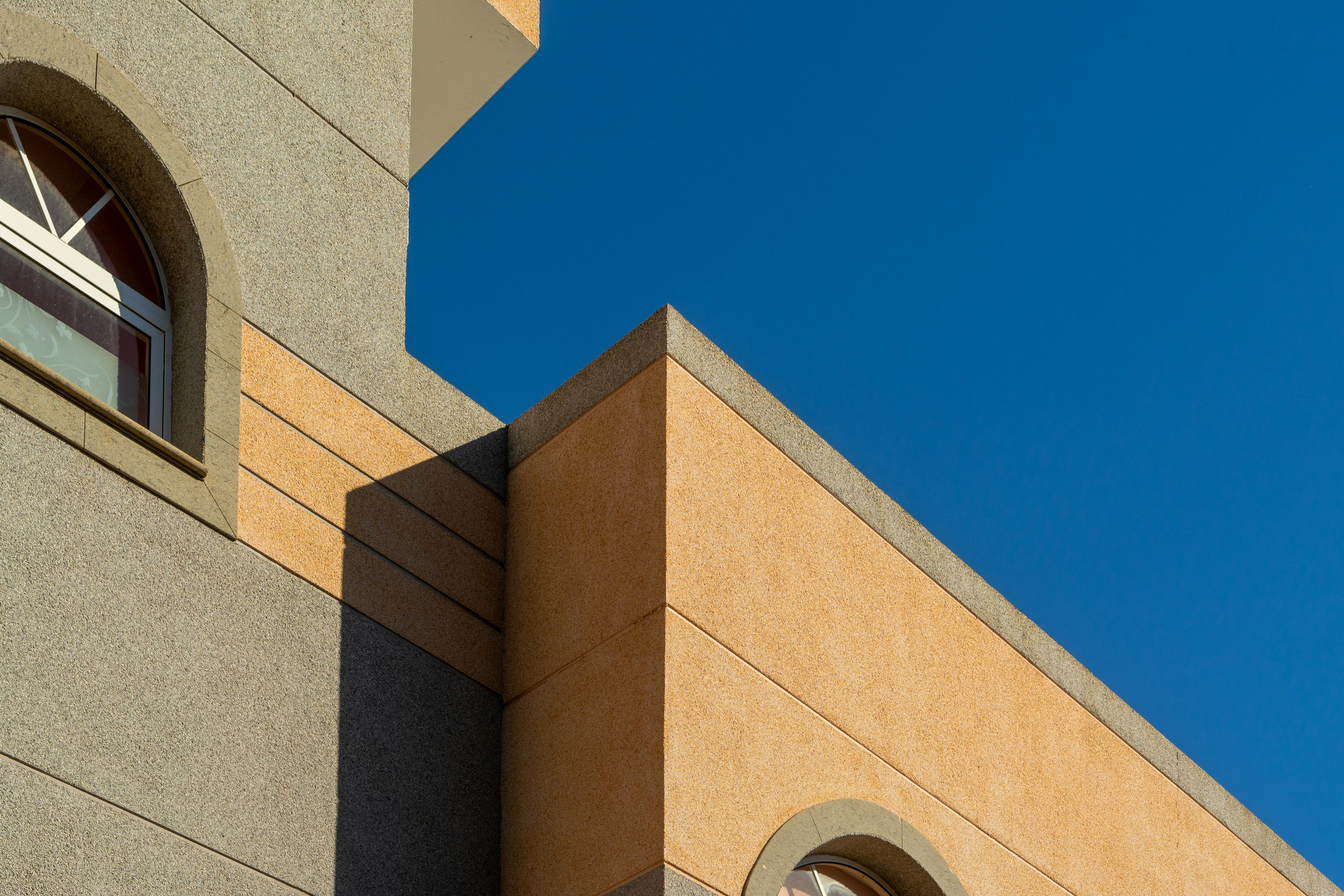 Corner of Modern Stone Building Casting Shadow on Wall · Free Stock Photo