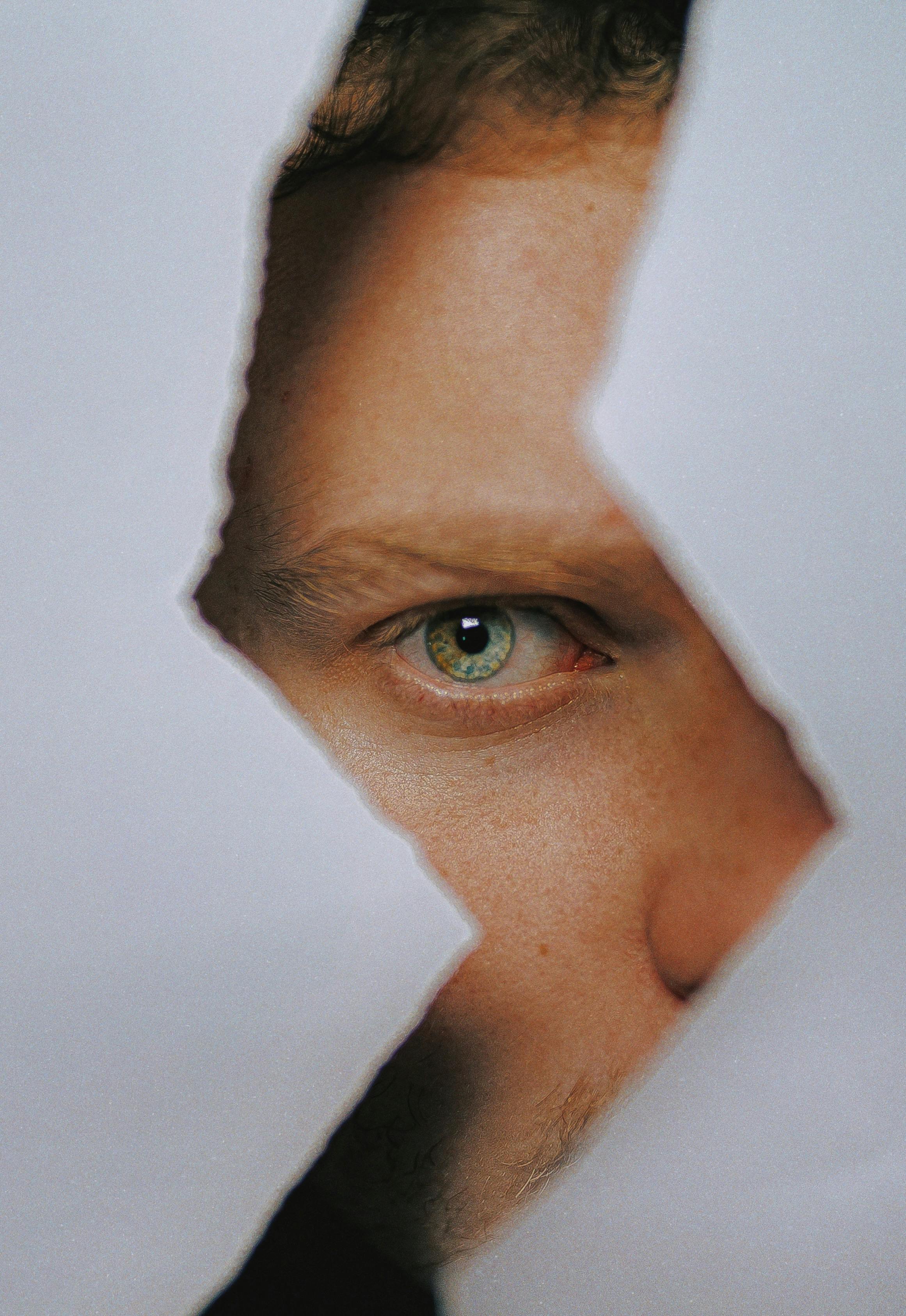 Eye Peeking through Gap in White Background · Free Stock Photo