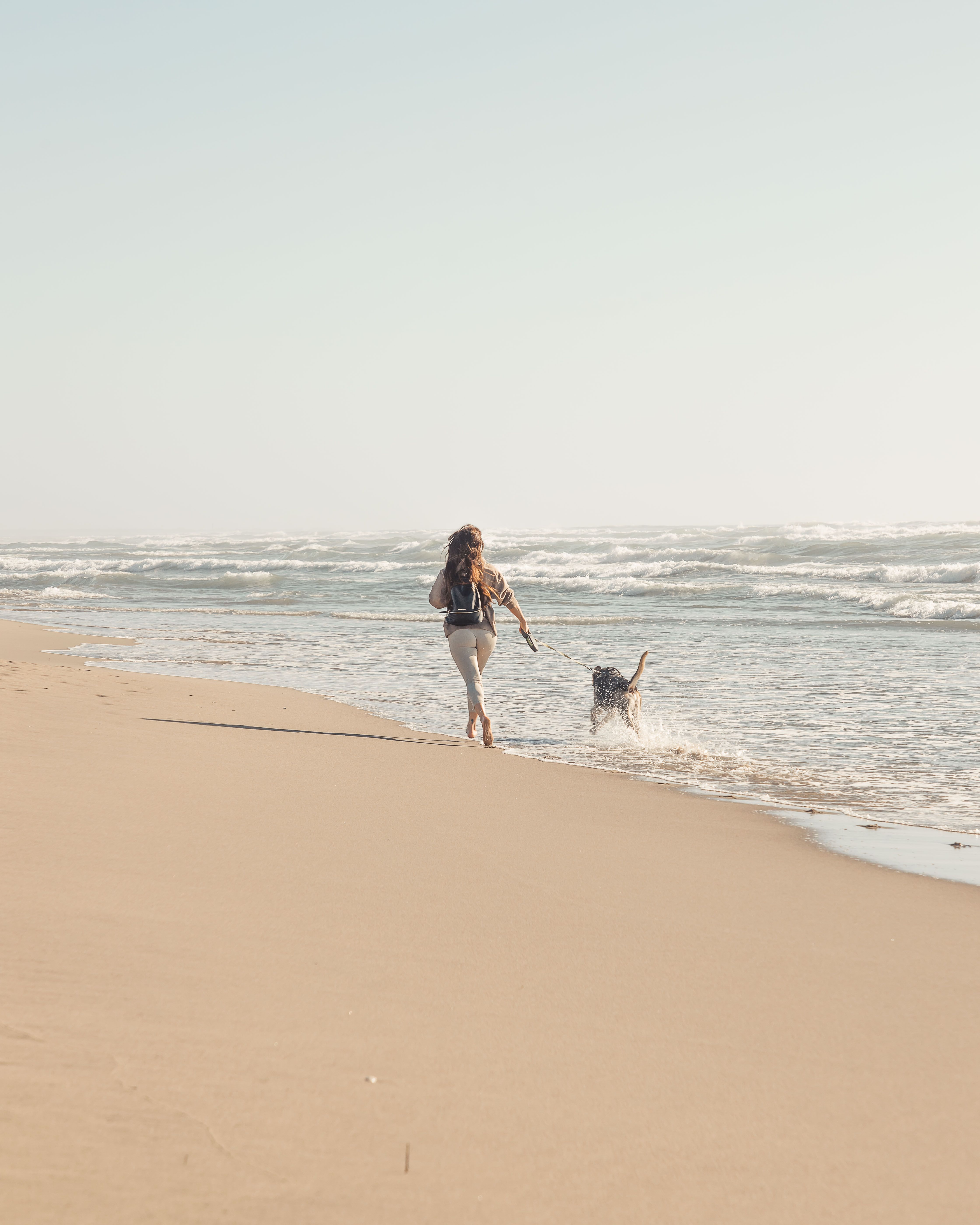 Woman Running with Dog on Beach · Free Stock Photo