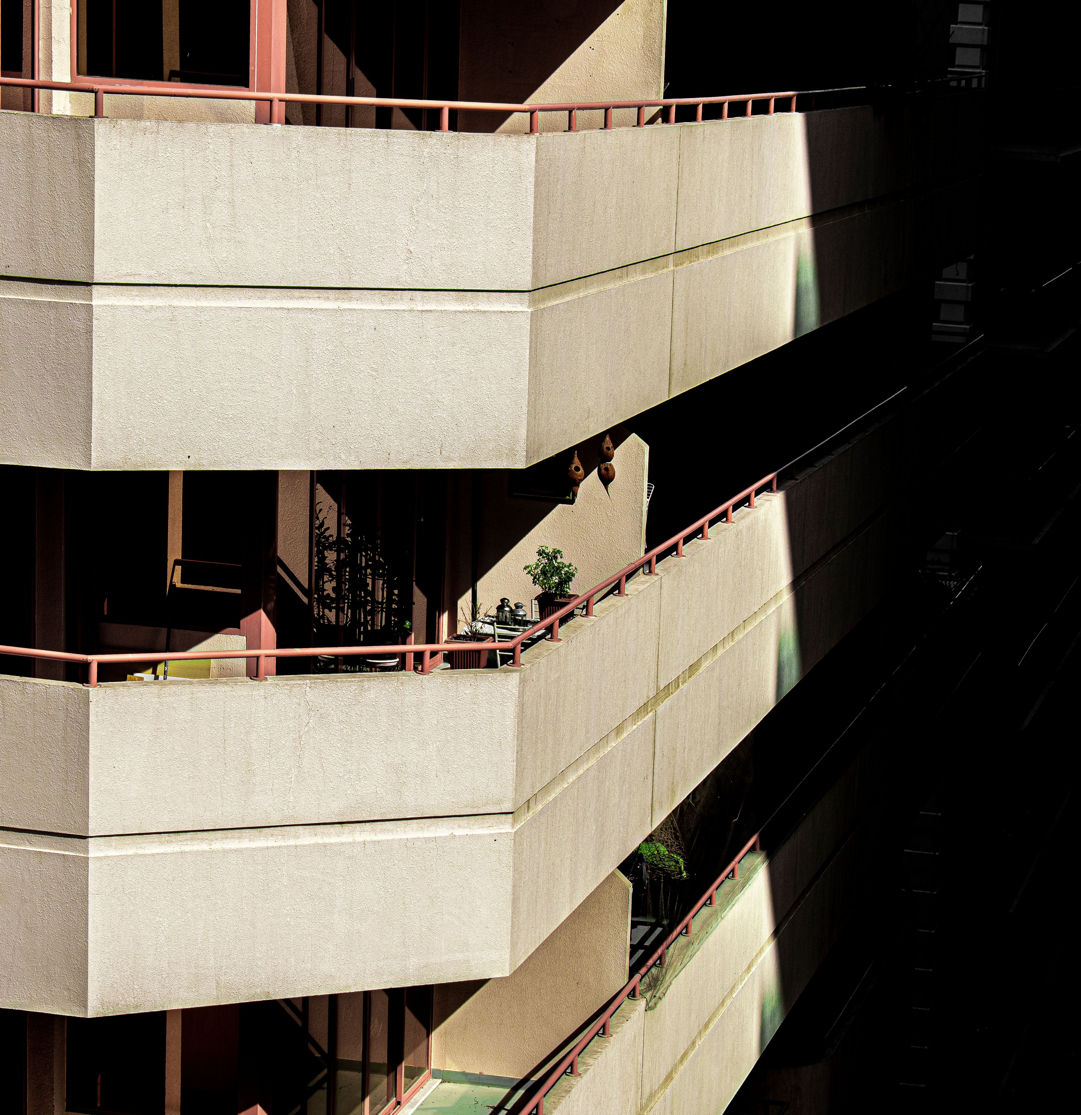 Sunlit Building Wall with Balconies · Free Stock Photo