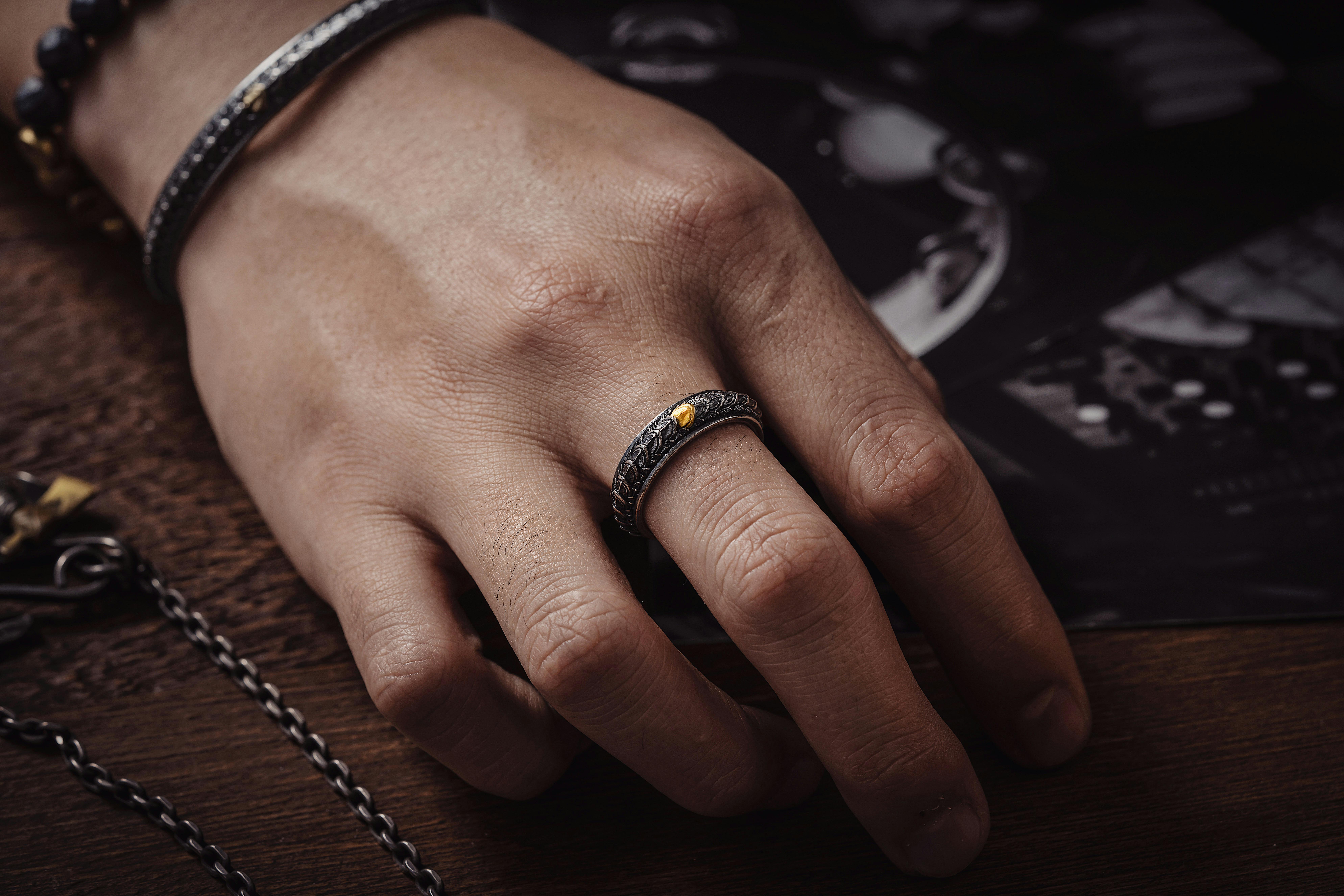 Person Wearing Silver Rings Holding Leather Garment · Free Stock Photo
