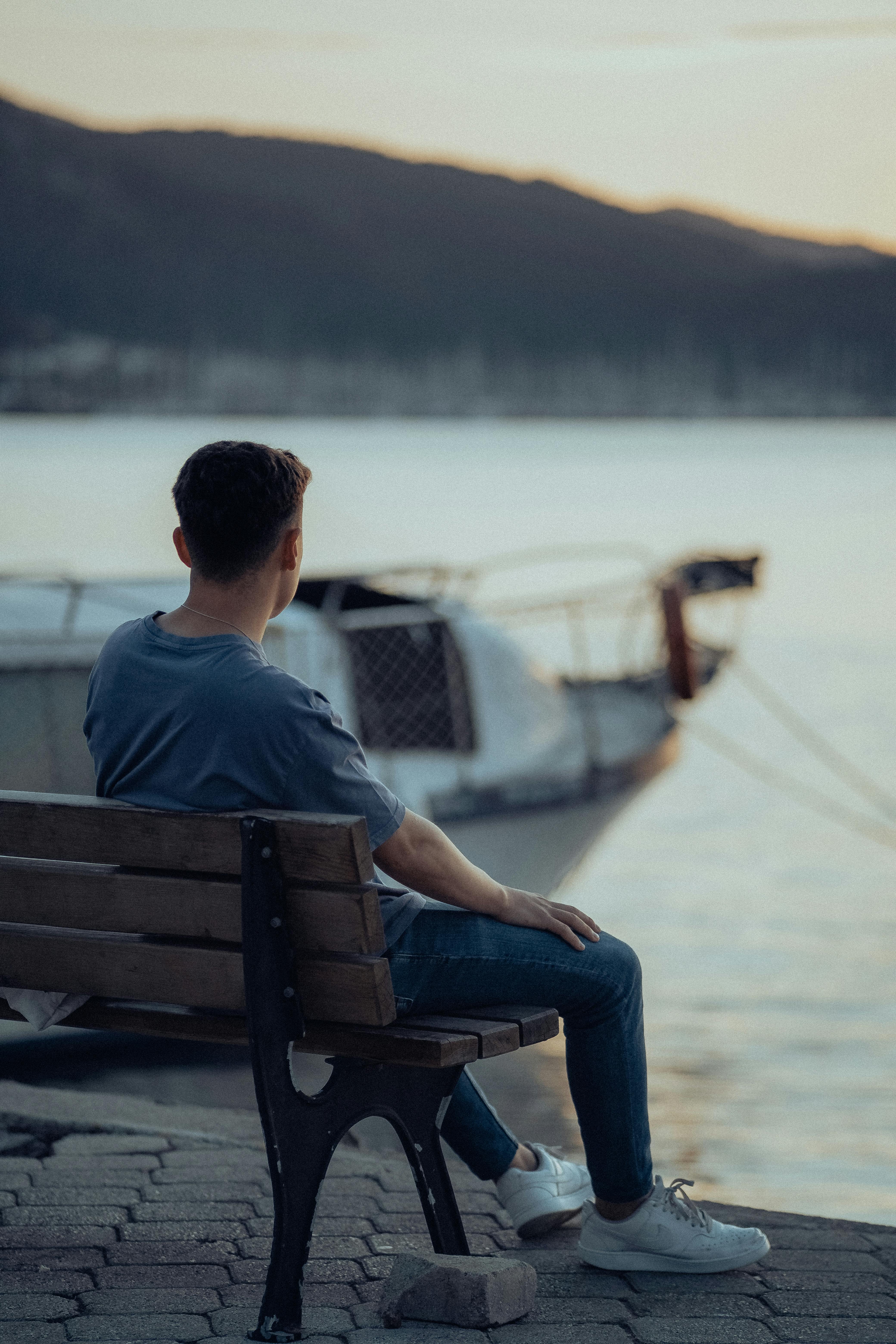 Man Sitting on Bench near Water · Free Stock Photo