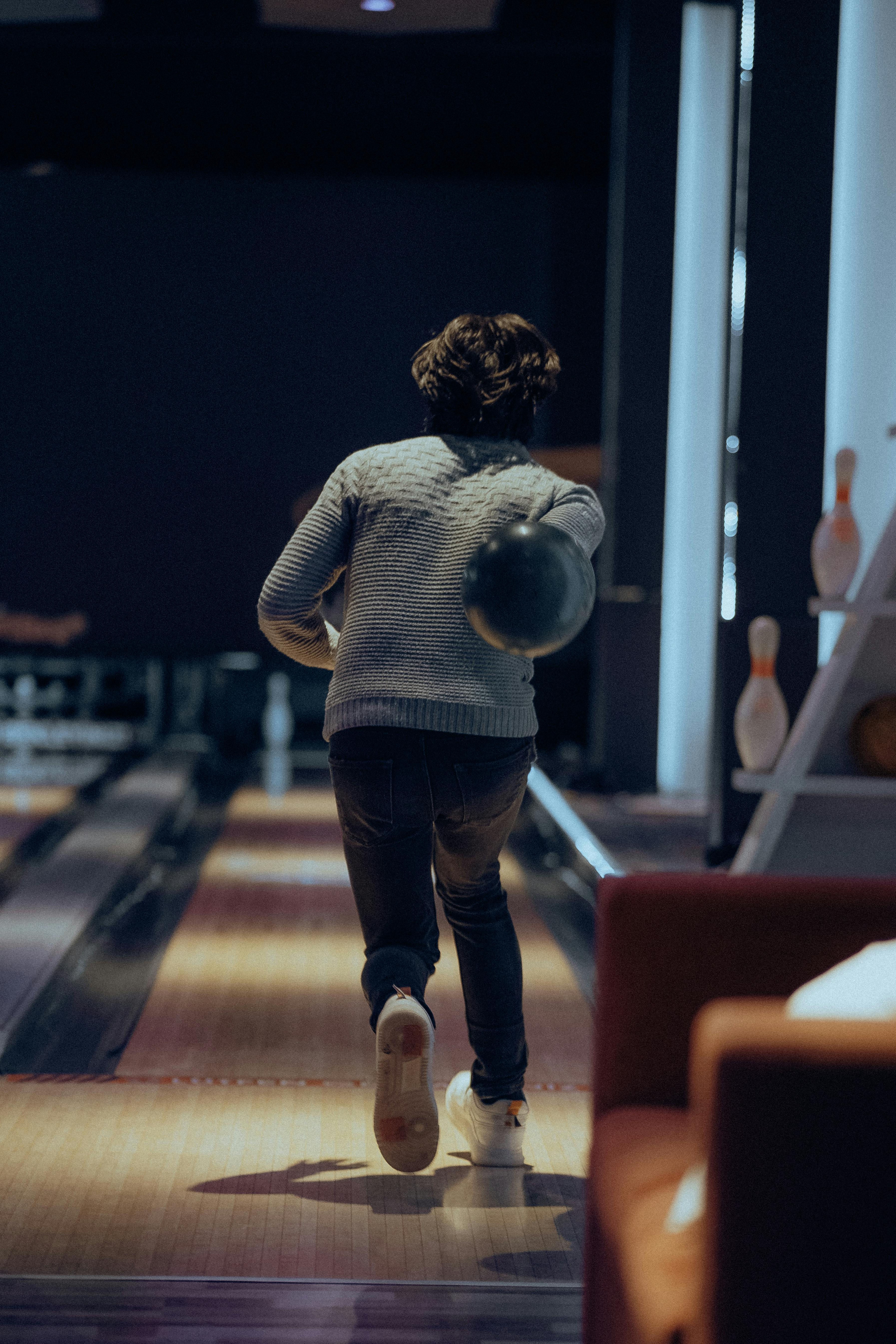 Back View of Person Throwing Bowling Ball · Free Stock Photo