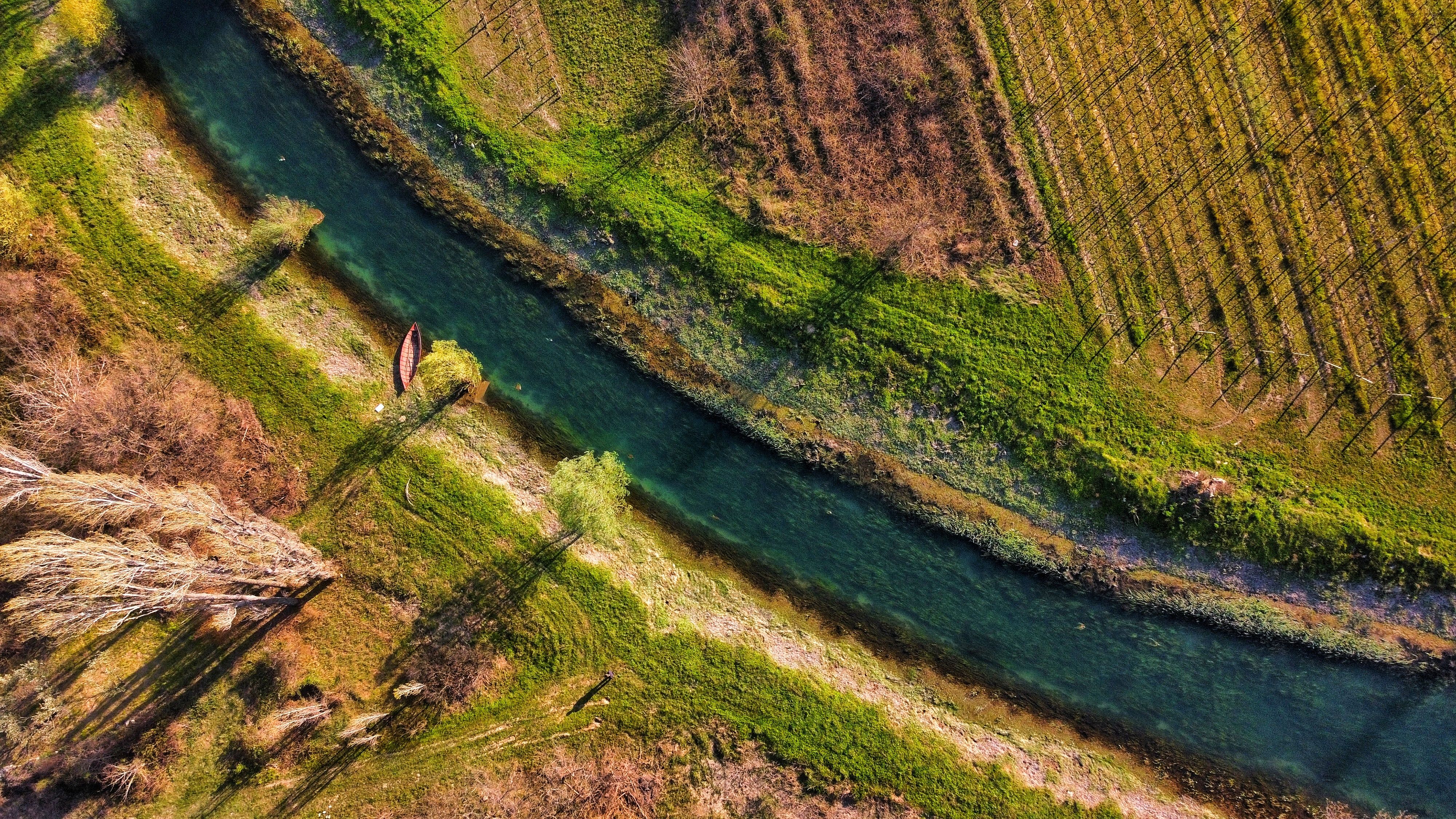 Top View of a River with a Small Boat on the Shore · Free Stock Photo