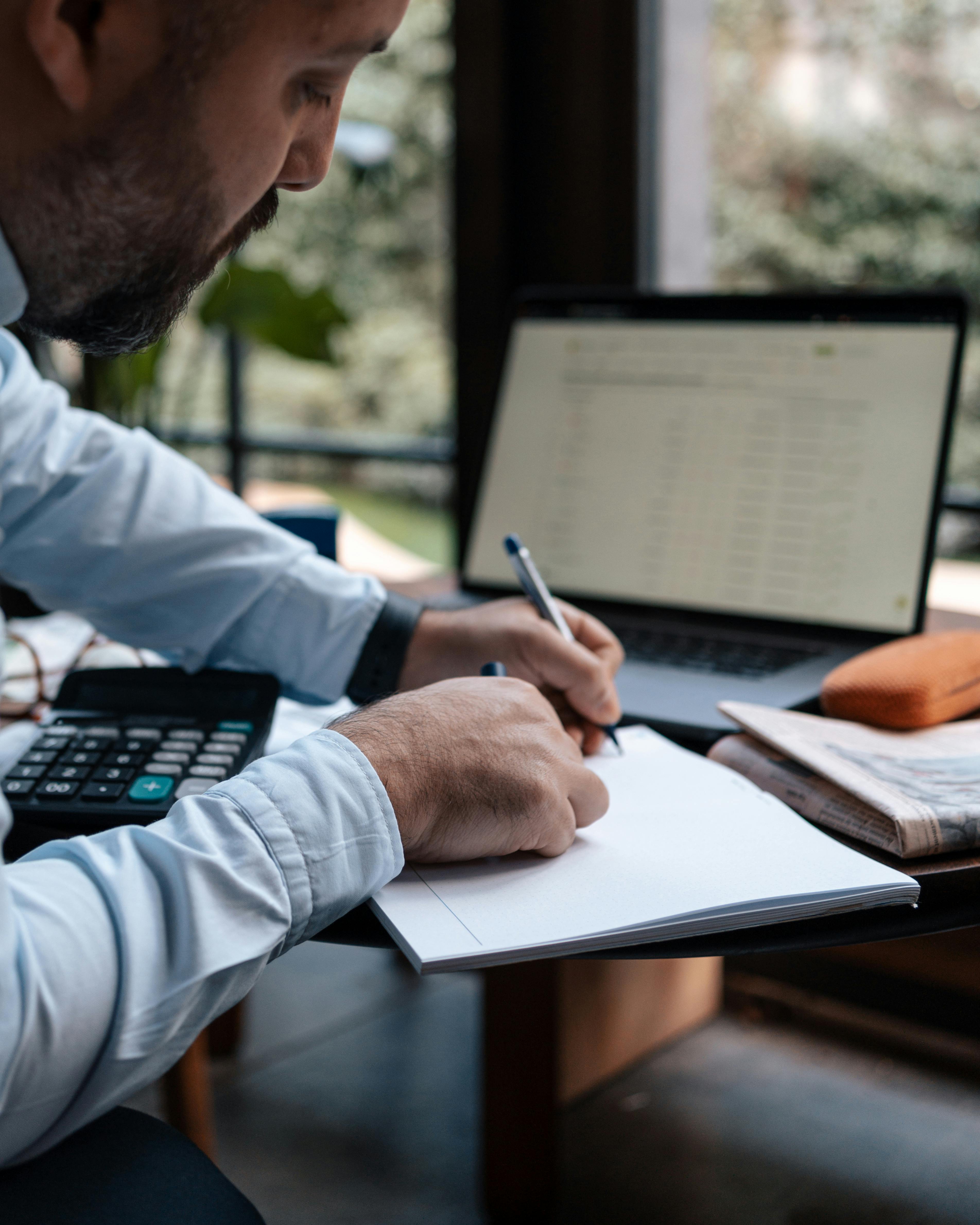 A Man Sitting Down and Writing · Free Stock Photo