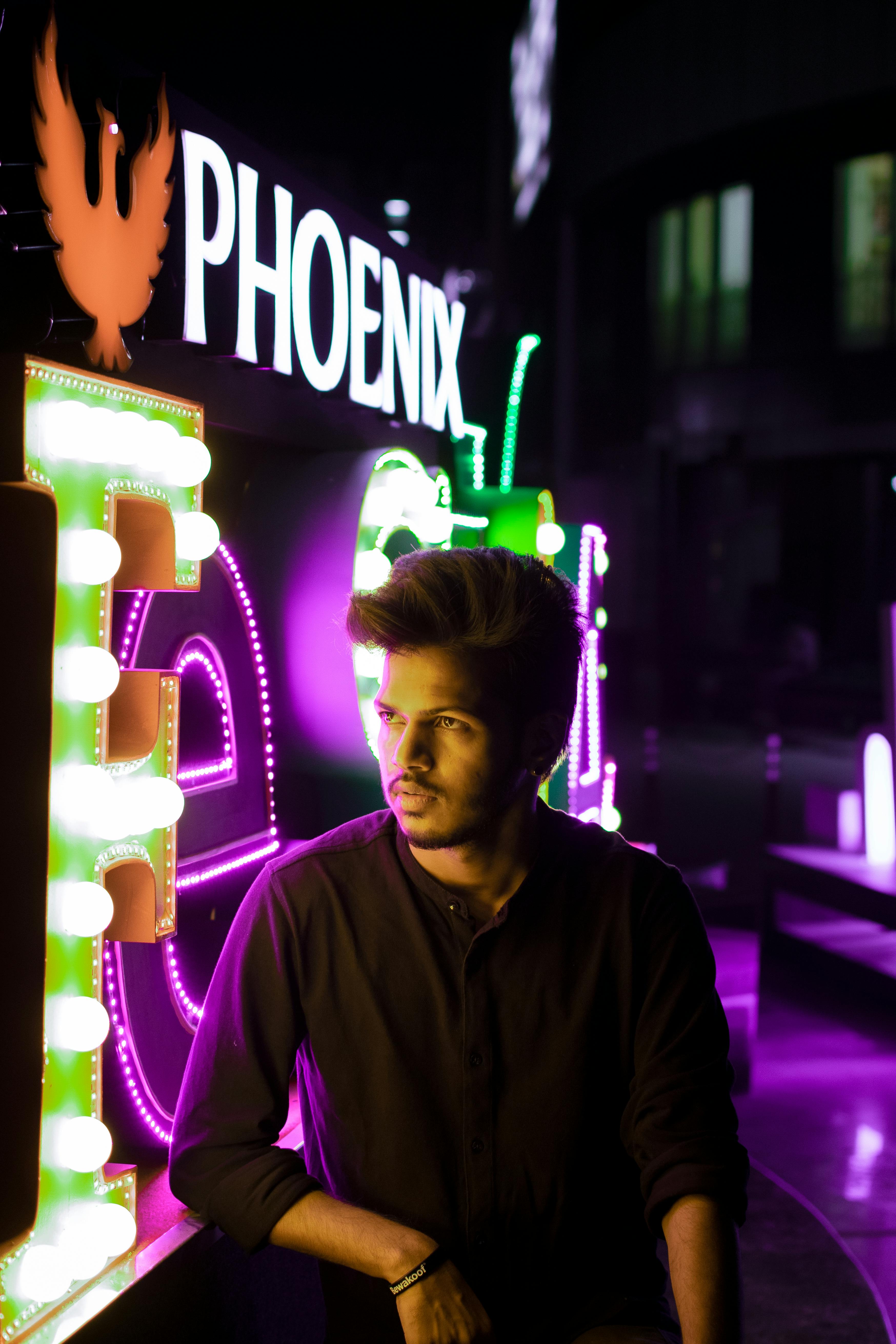Smiling Man Standing Beside Neon Signage · Free Stock Photo