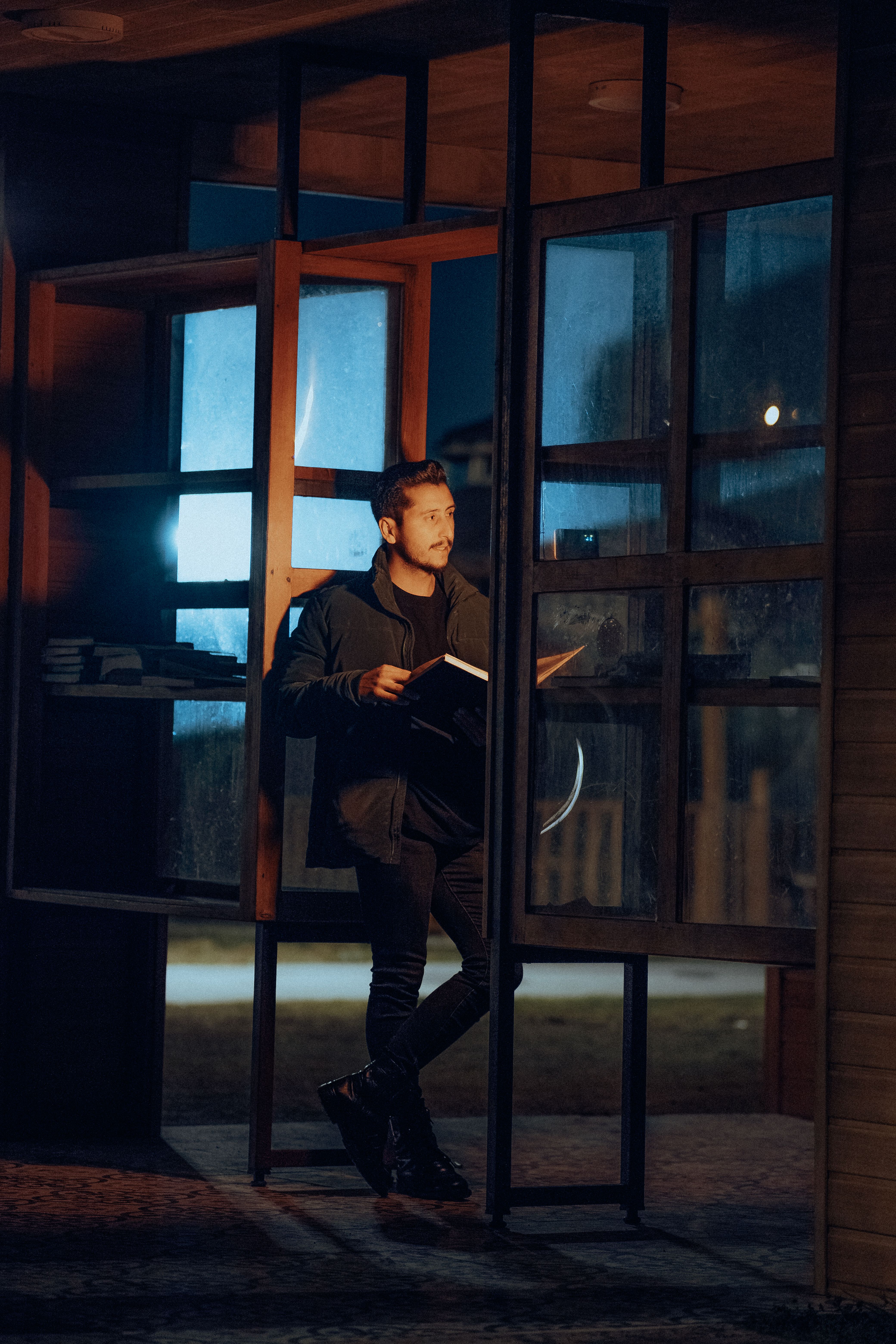 Man Posing with Books in Doors Windows · Free Stock Photo