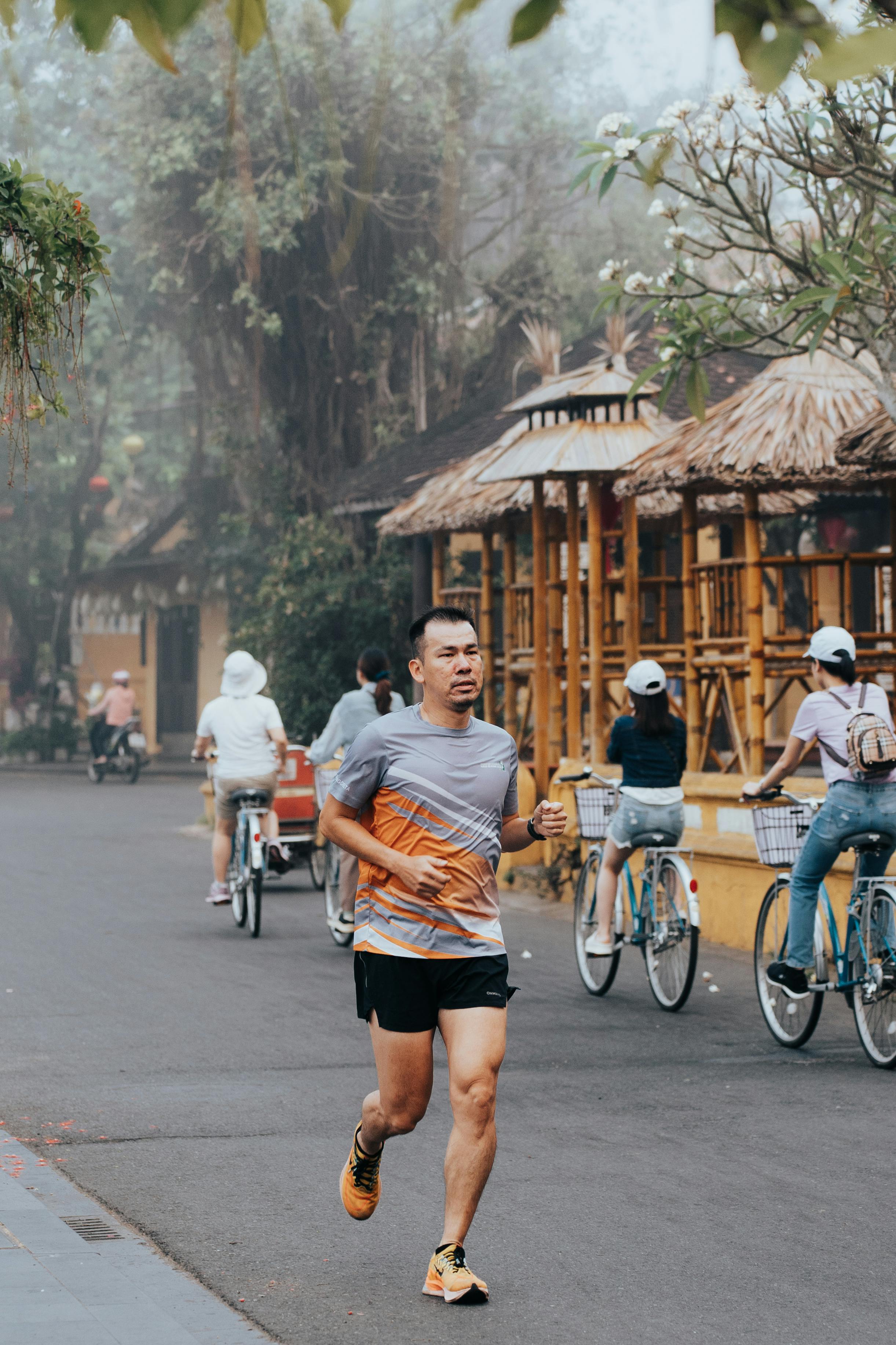 Man Running and People Cycling in Village · Free Stock Photo