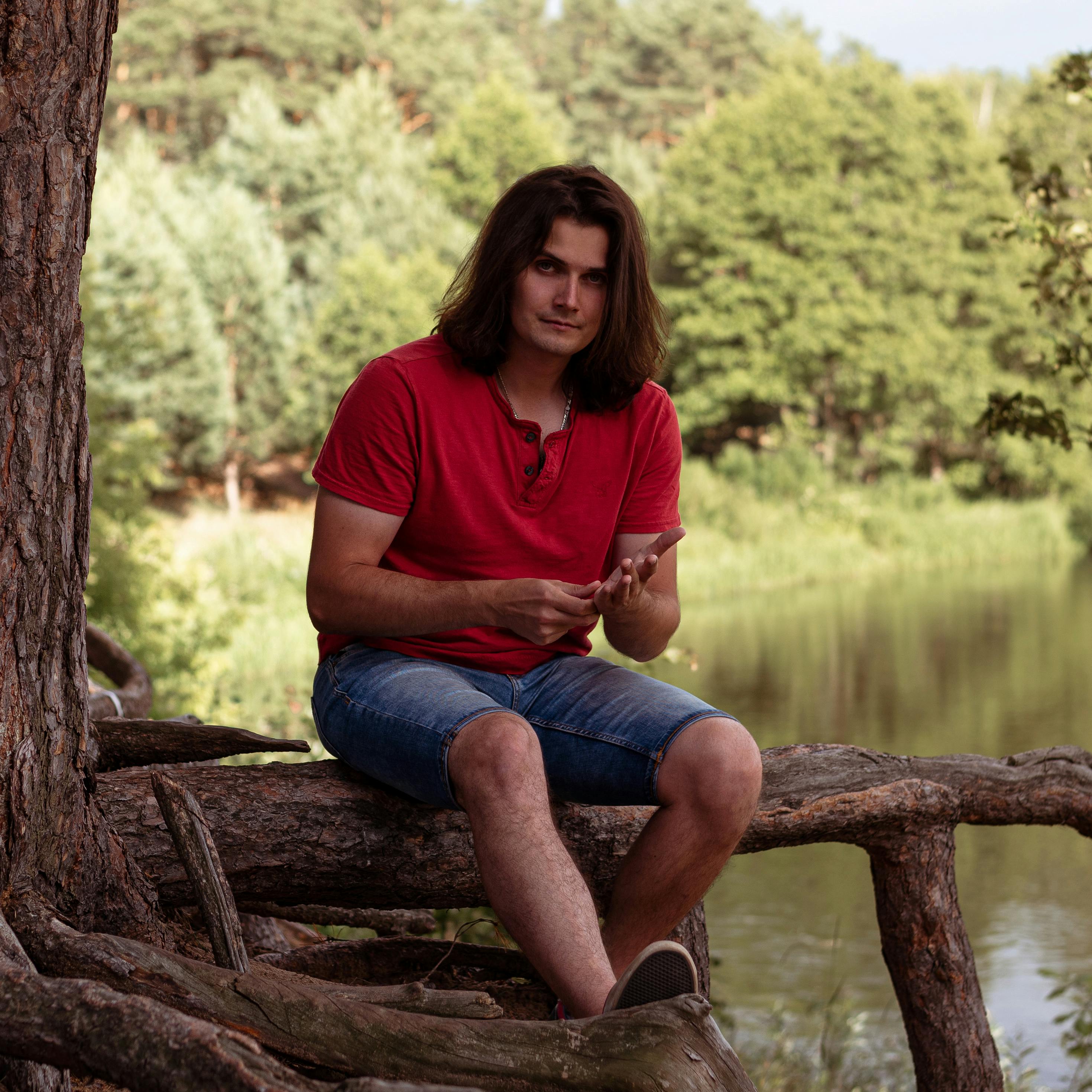 Man Sitting and Posing on Tree Roots · Free Stock Photo