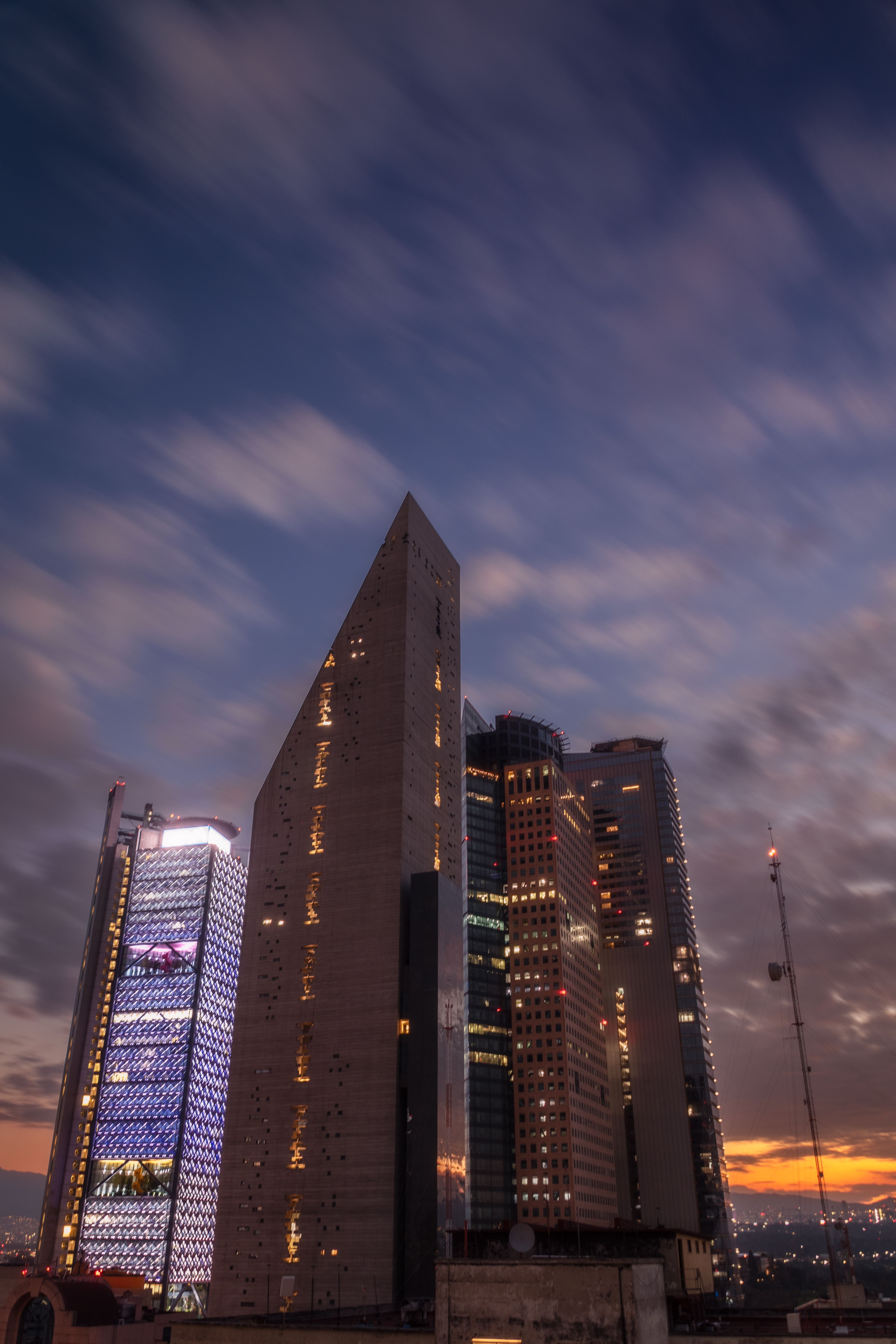 A city skyline at dusk with buildings and clouds · Free Stock Photo