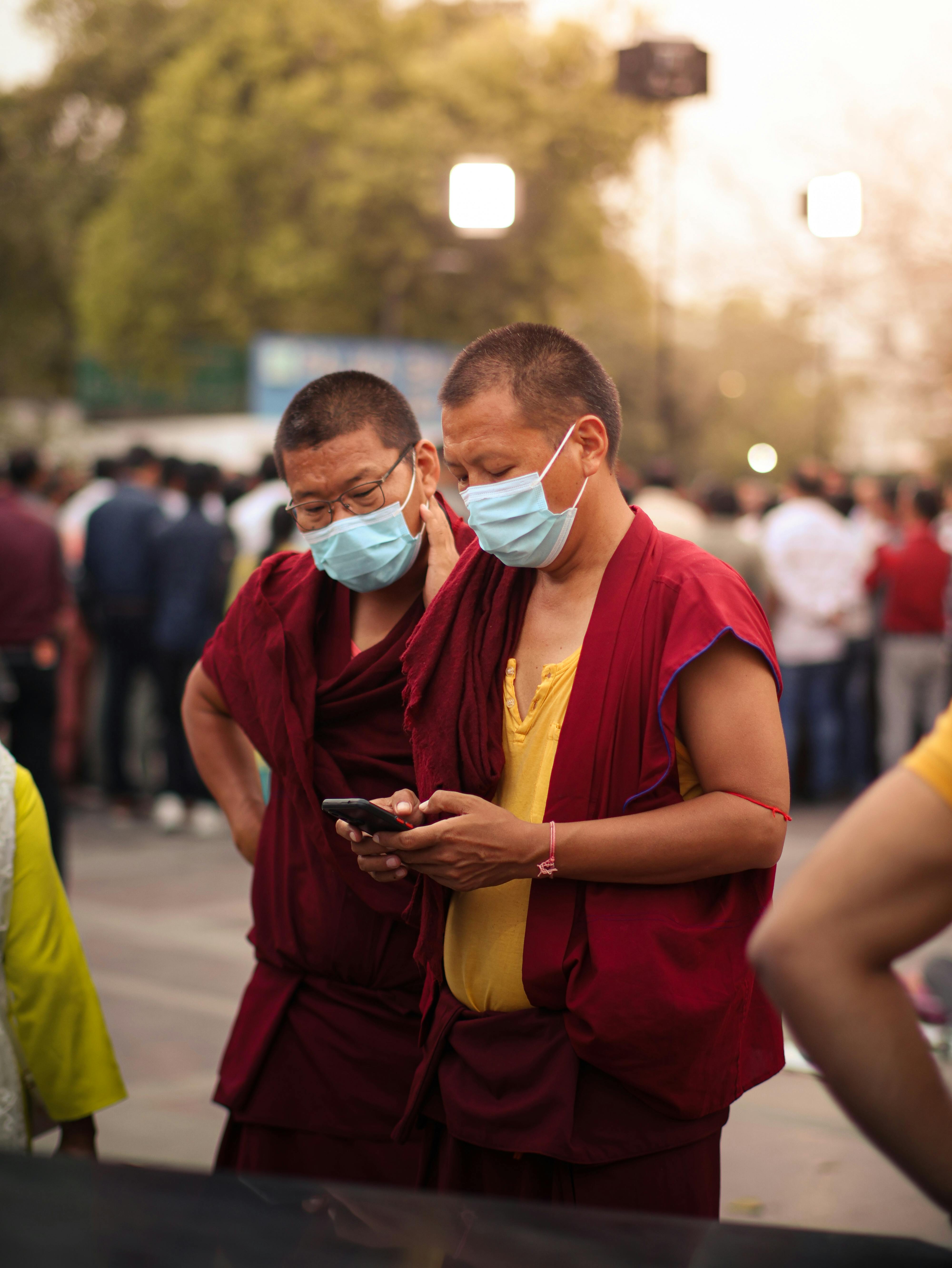 Tibetan Monks in Face Masks Using Cellphone · Free Stock Photo