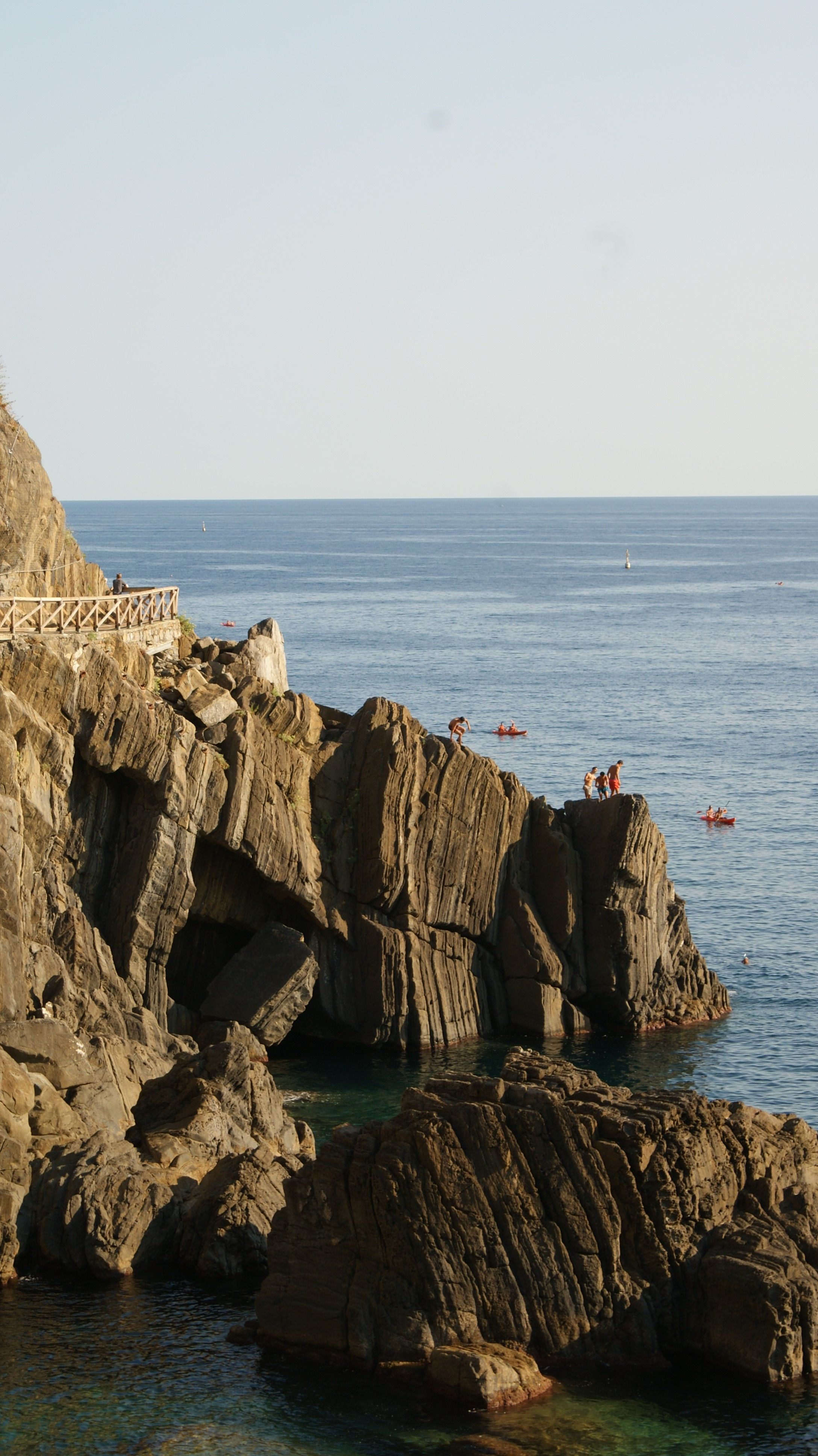Coastal Cliff with People Swimming in the Background · Free Stock Photo