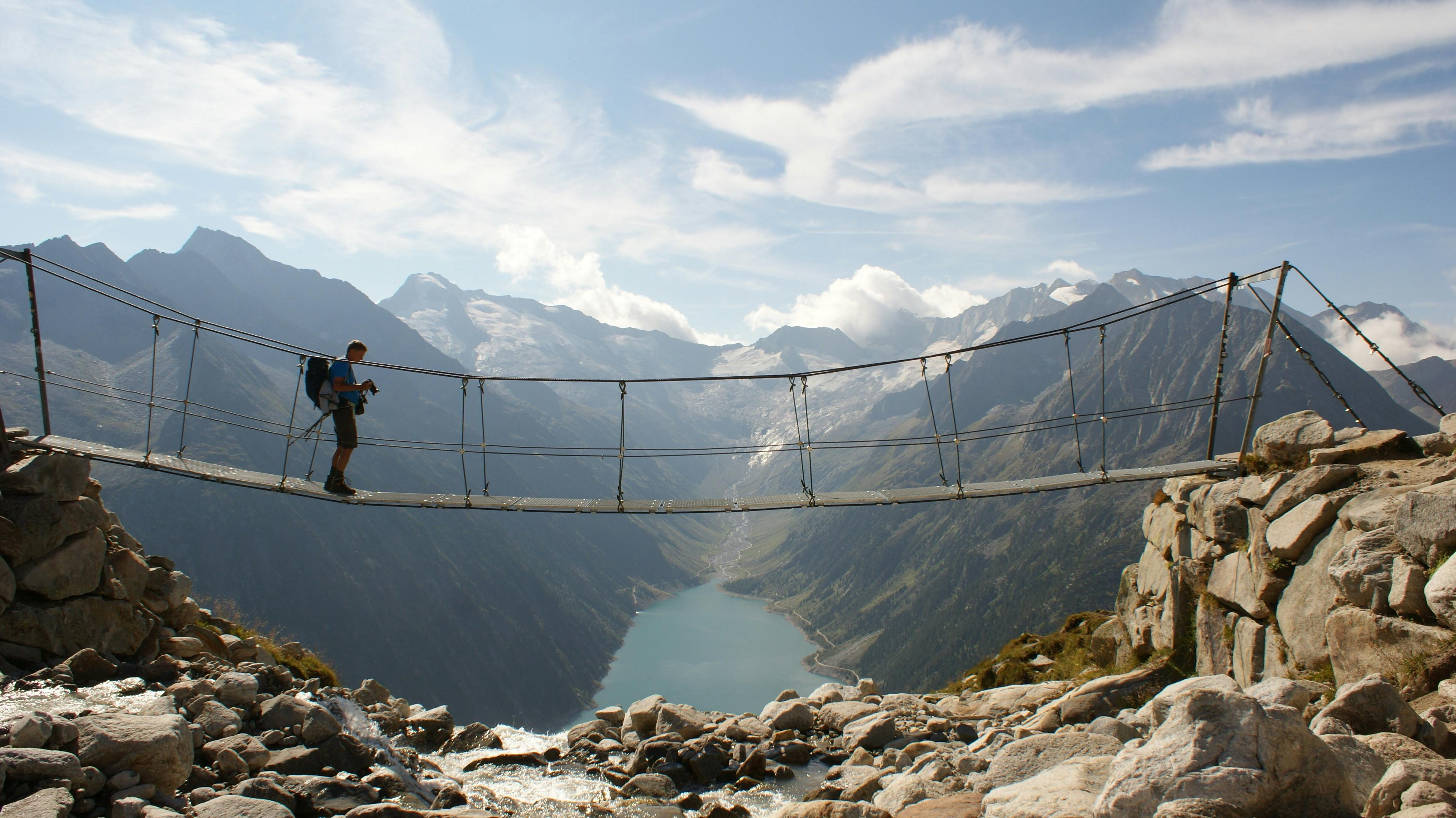 Man Walking on Suspension Bridge in Mountains Landscape · Free Stock Photo