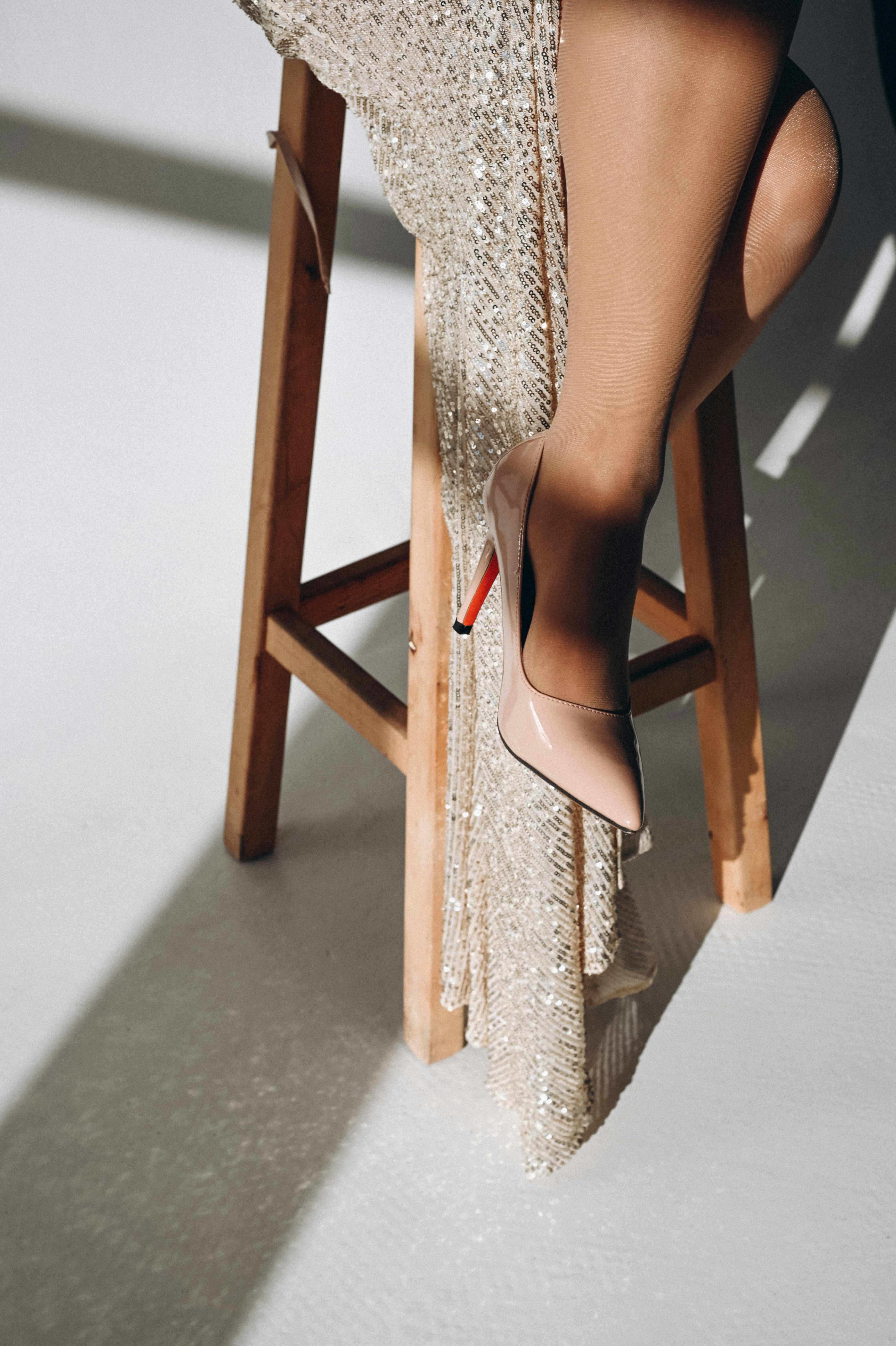Legs of a Woman Wearing High Heels Sitting on a Stool · Free Stock Photo