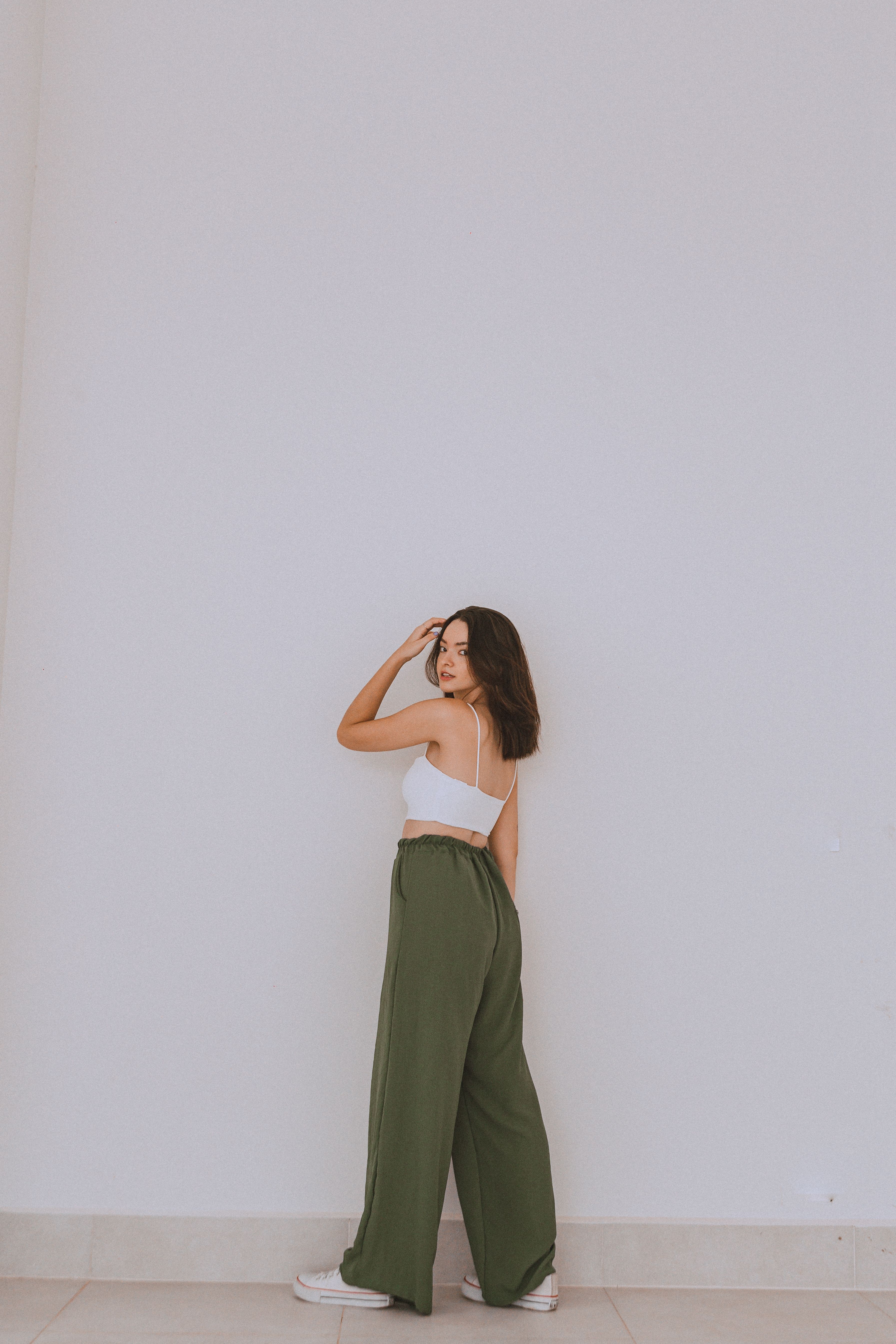 Studio Shot of a Young Woman in a White Crop Top and Khaki Trousers ...