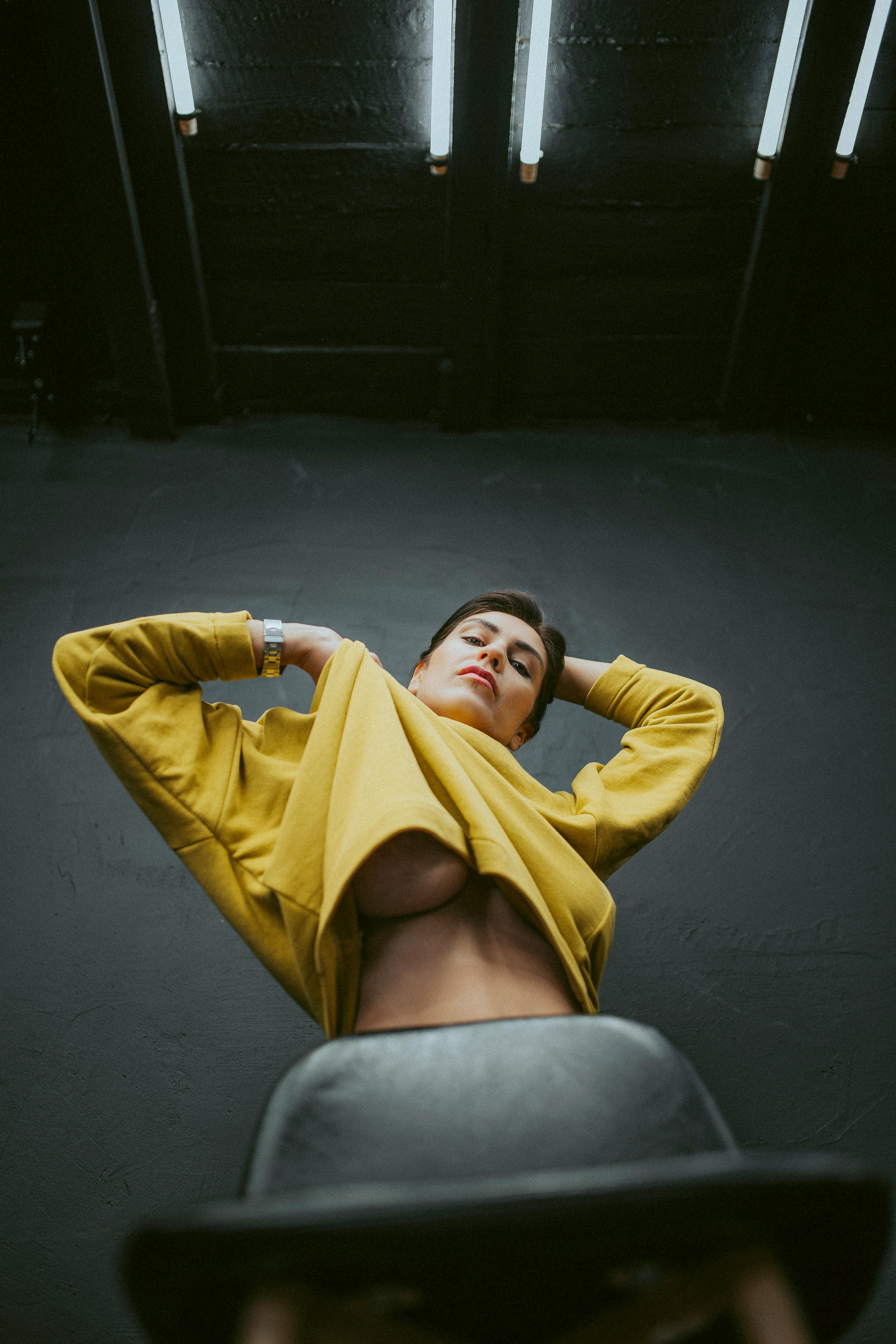 Woman in Yellow Clothes Undressing behind Chair · Free Stock Photo