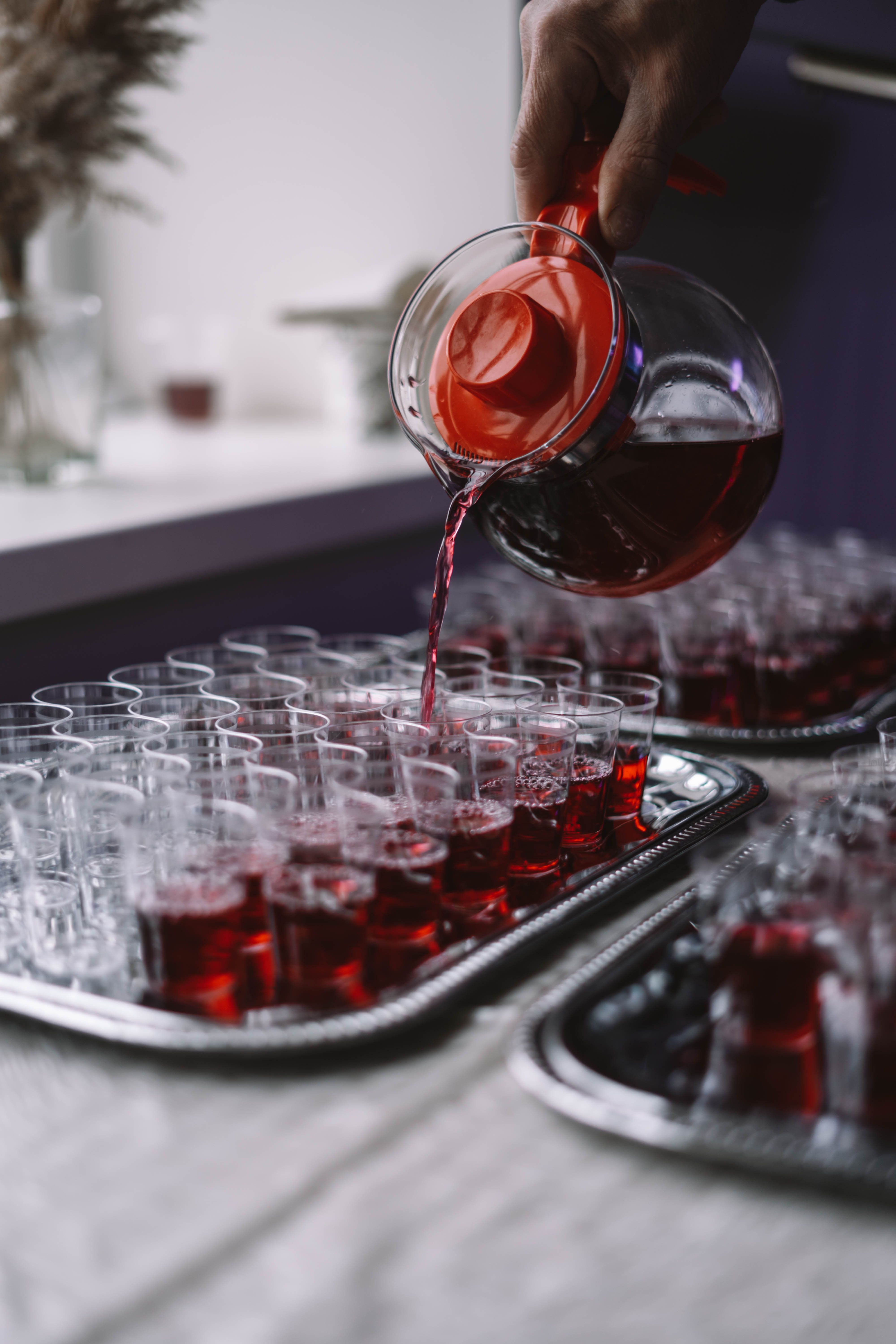 A person pouring red liquid into glasses · Free Stock Photo