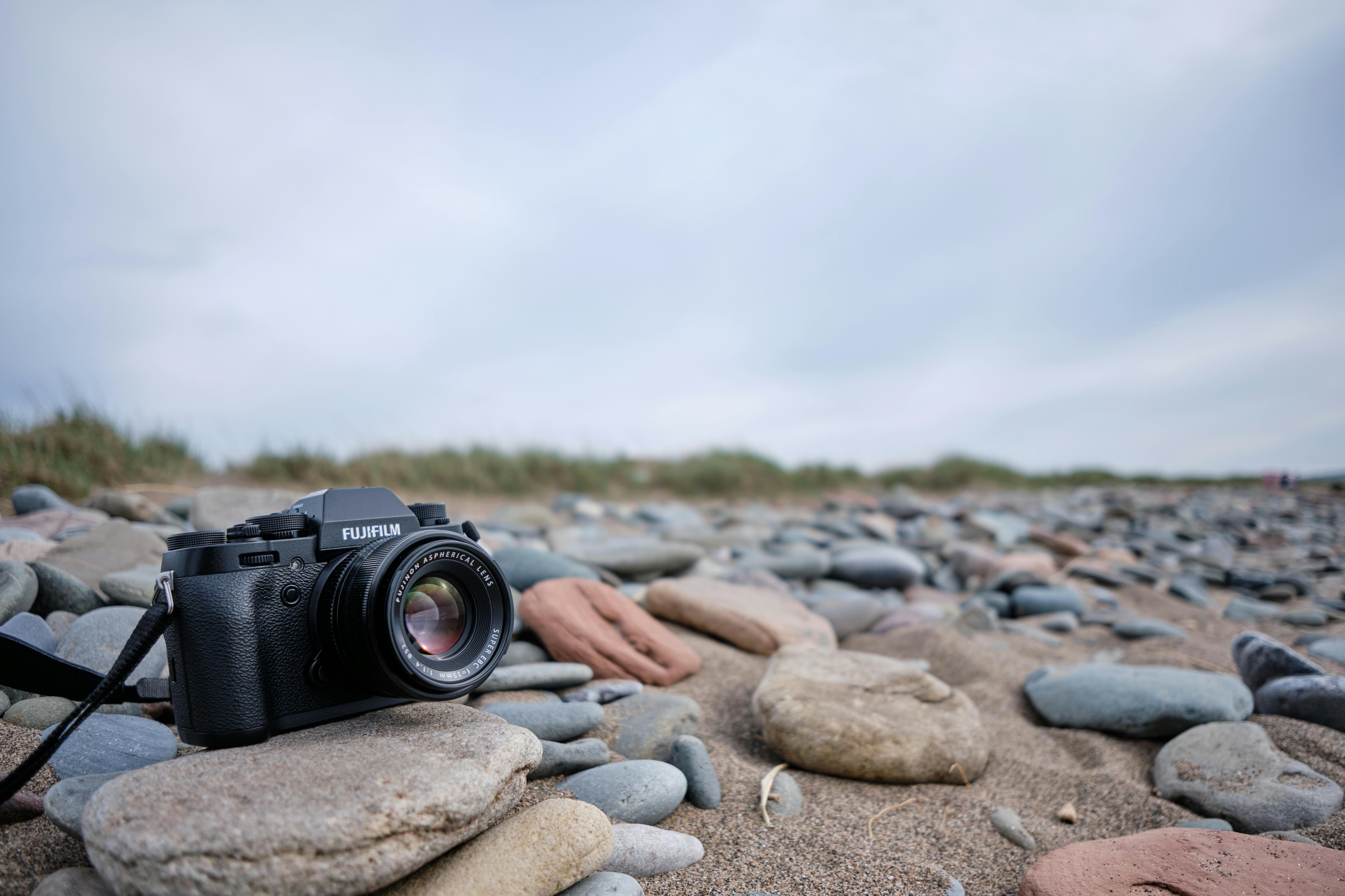 Camera on Stones on Sand · Free Stock Photo